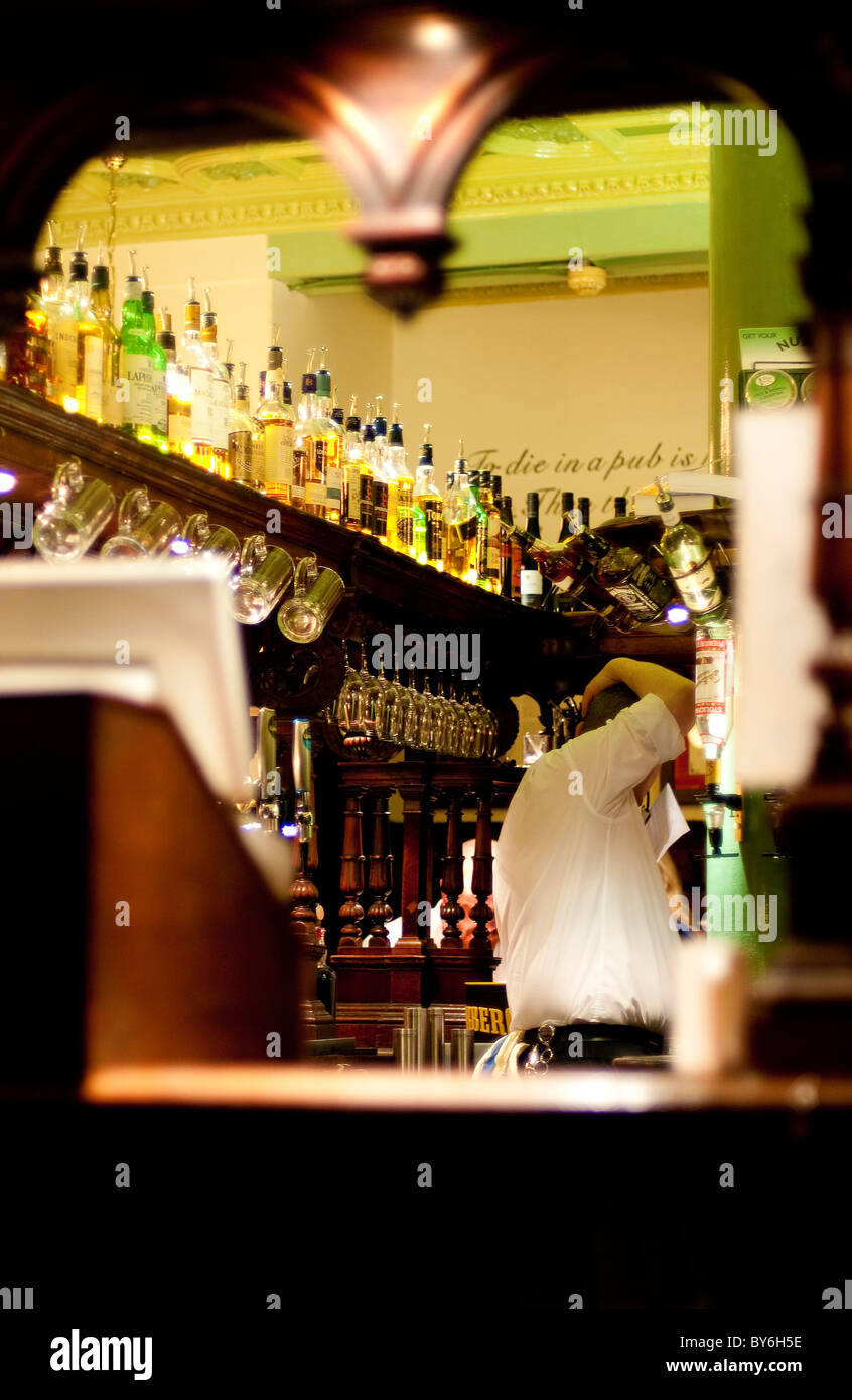 Barman with head in hands in a Scottish pub (with "To die in a pub is ...