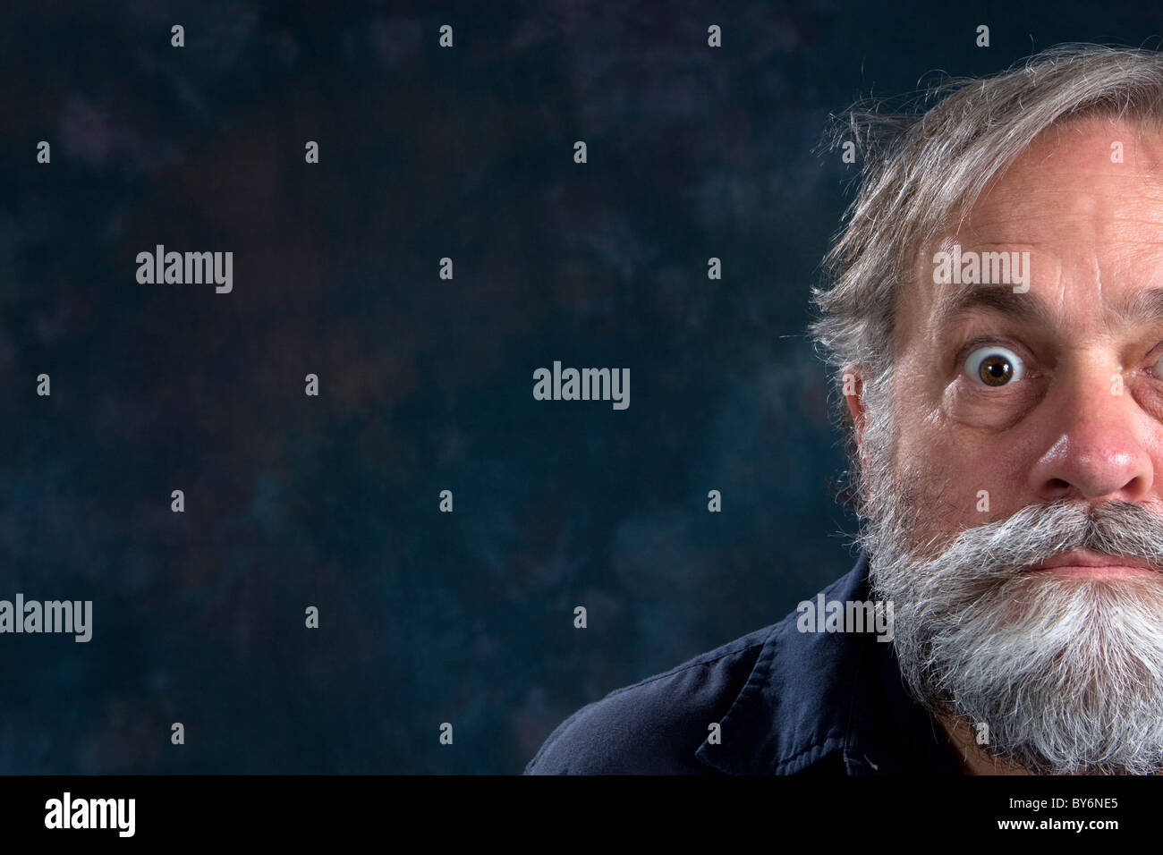Half the face of a bug eyed mature man with beard Stock Photo - Alamy