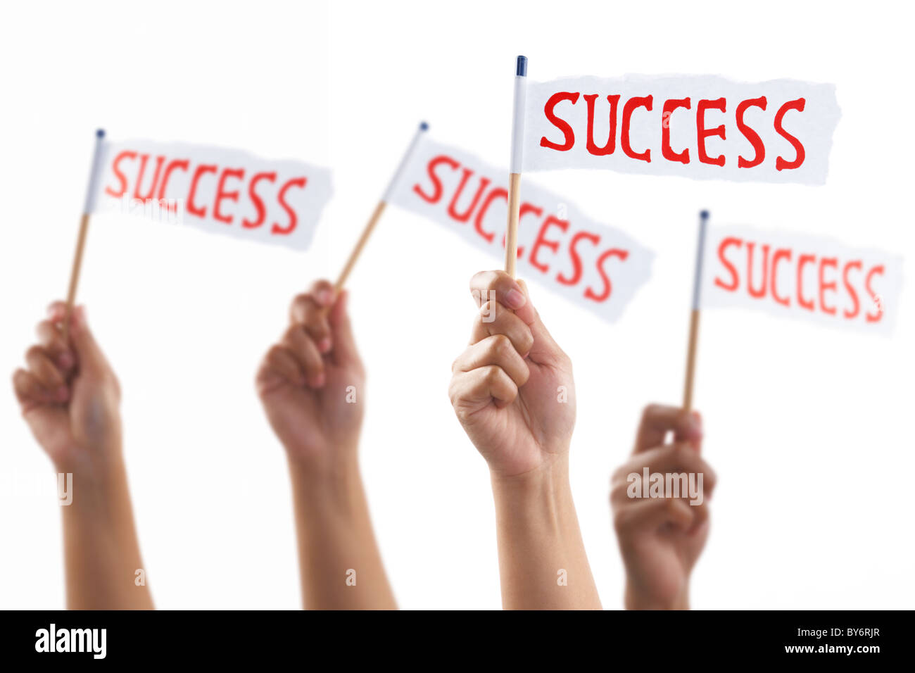 Hands uprising and holding success flag, shot aginst white background ...
