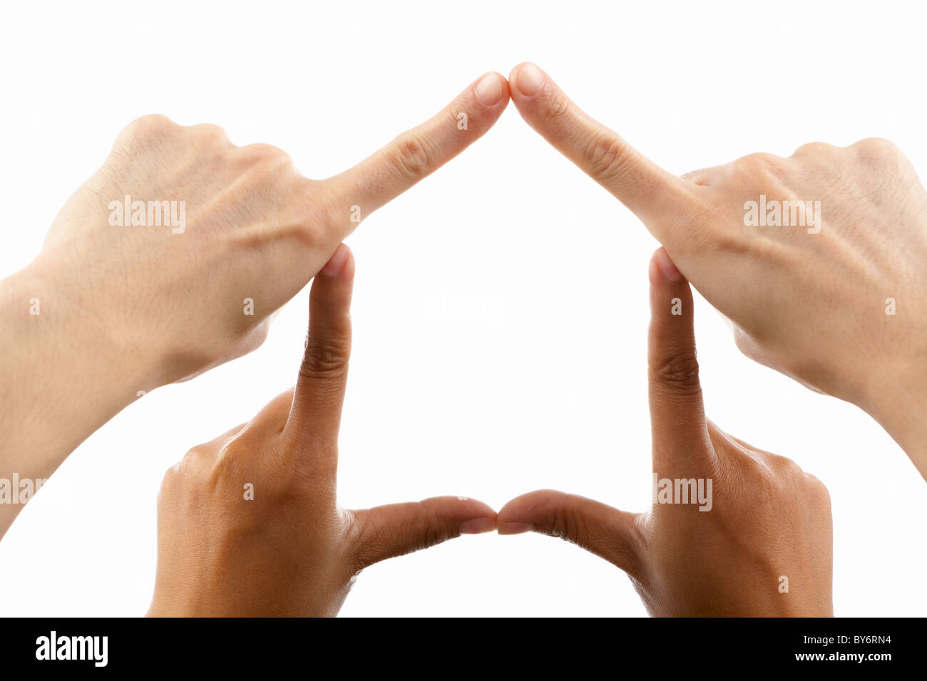 Multi ethnic couple's hands forming house symbol, against white ...