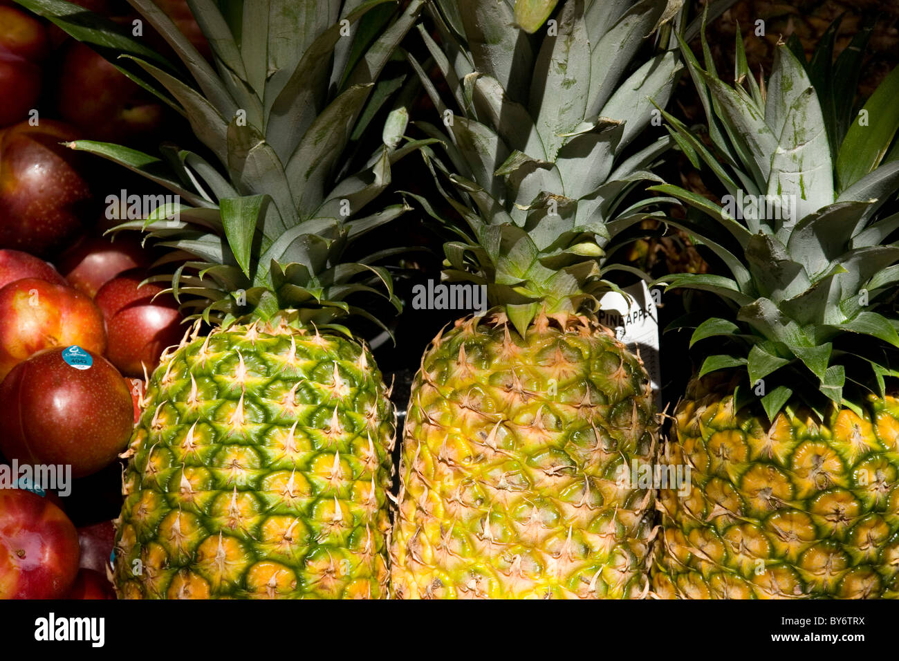 Pineapple and nectarine produce in market, up close Stock Photo - Alamy