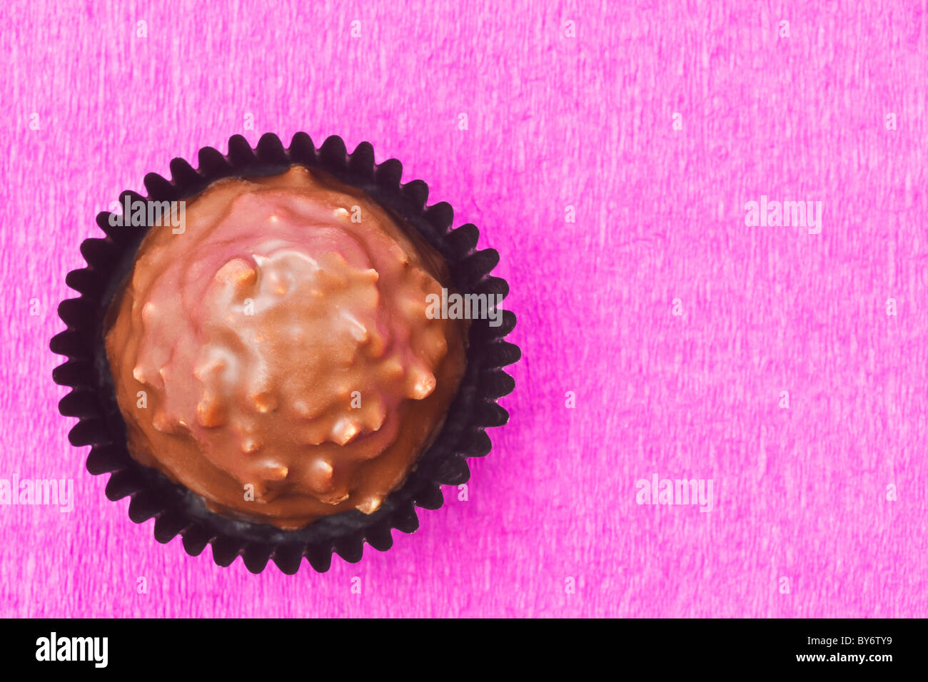 Milk chocolate sweet with hazelnut flakes on pink background Stock ...