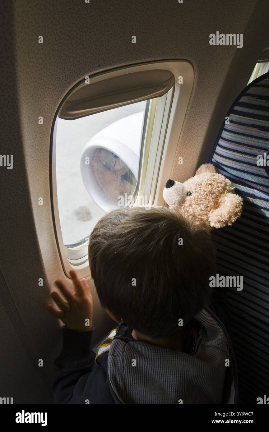 Boy looking through airplane window, Munich airport, Bavaria, Germany ...
