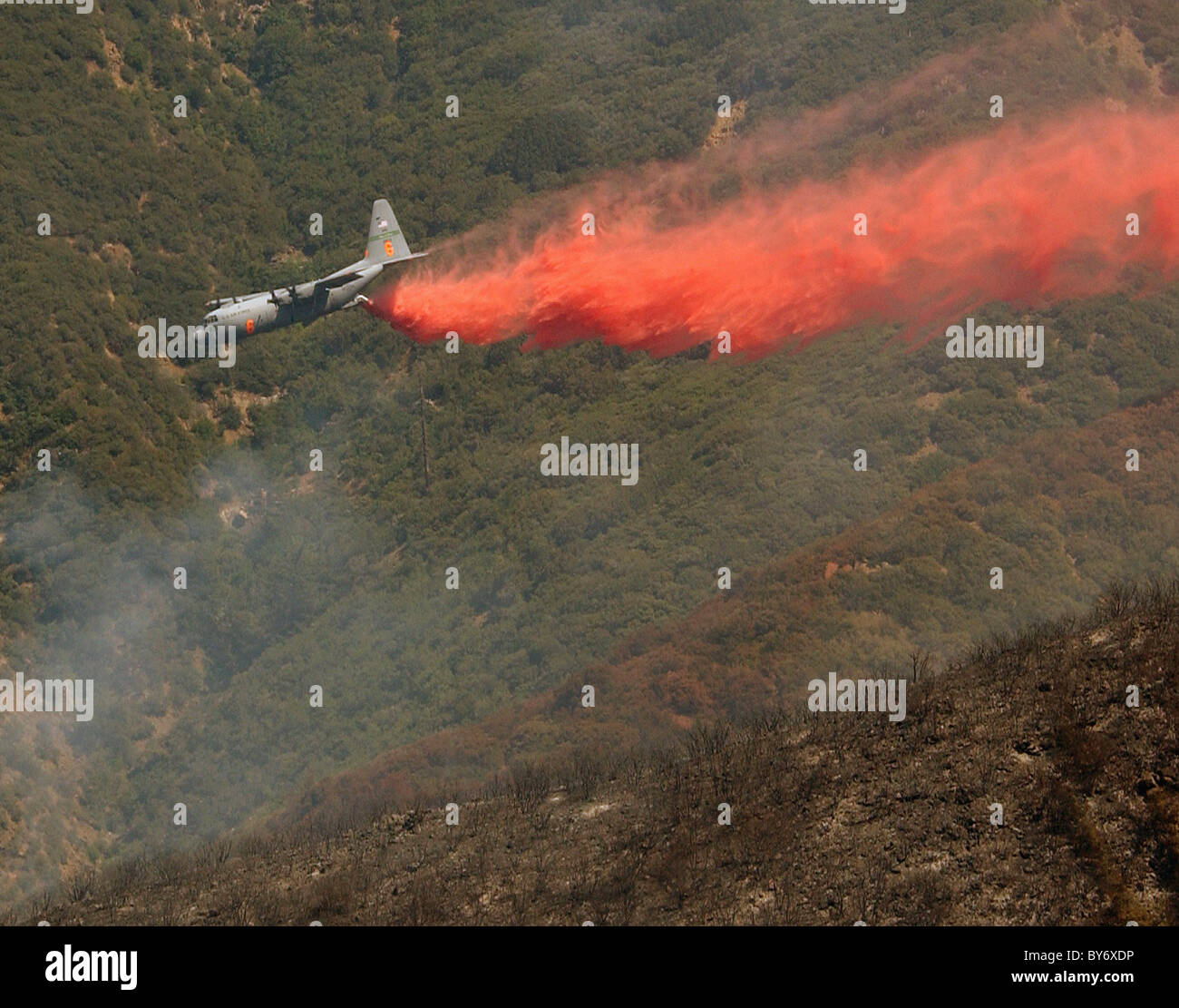 airplane dropping fire retardant over forest wildfire Stock Photo - Alamy