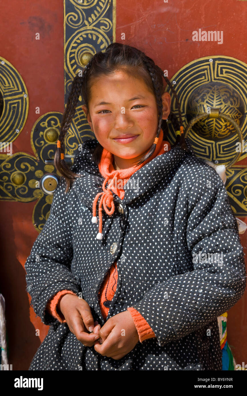 Tibetan girl in front of entrance to house in Tibetan village on the ...