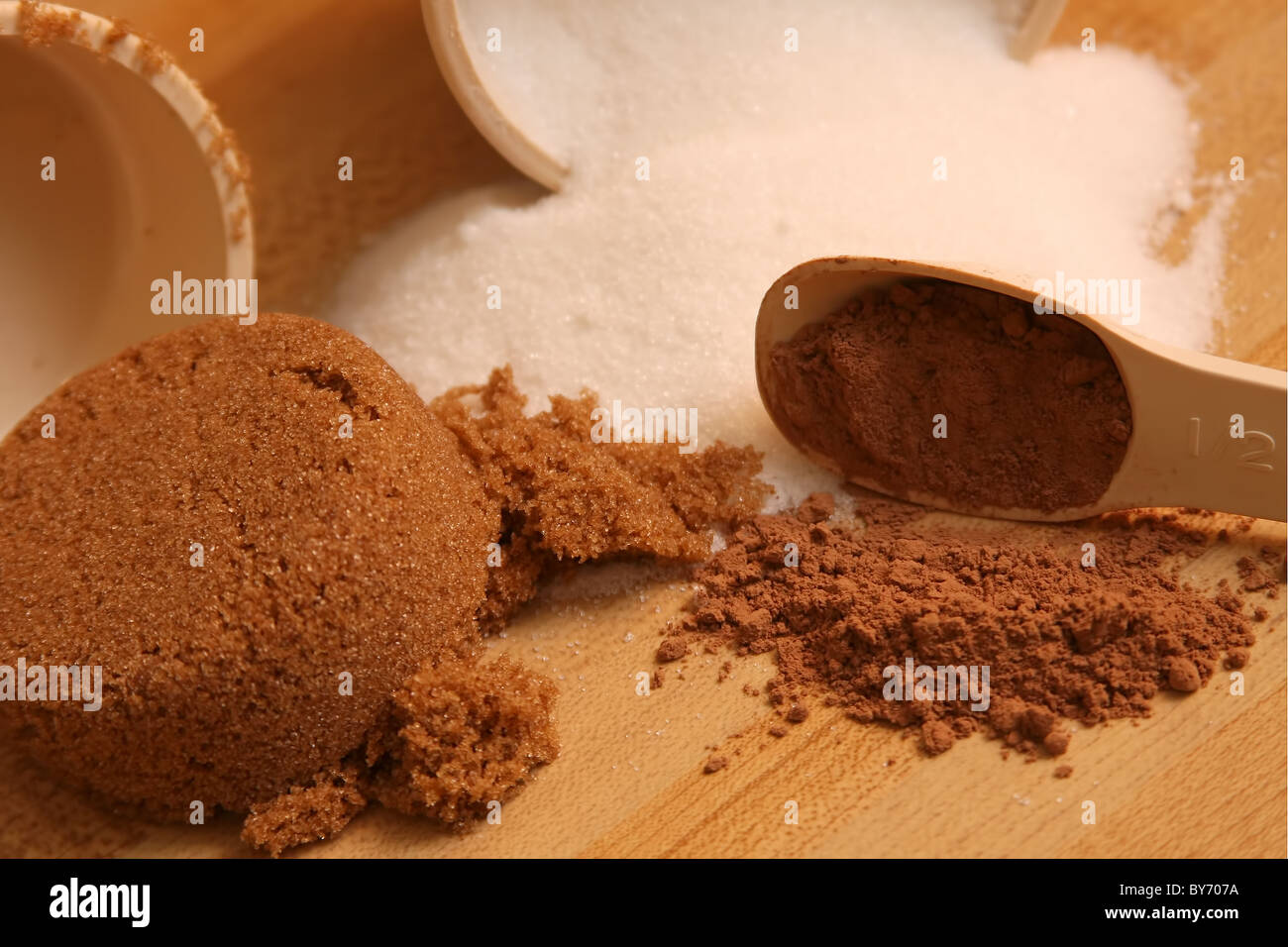 cocoa and sugar spilling out of measuring cup and spoon Stock Photo - Alamy