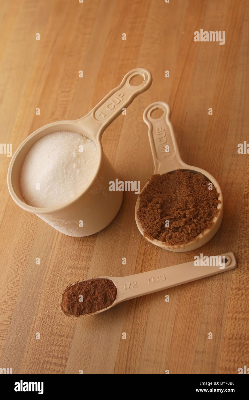 measuring cups and spoon with sugar and cocoa Stock Photo - Alamy
