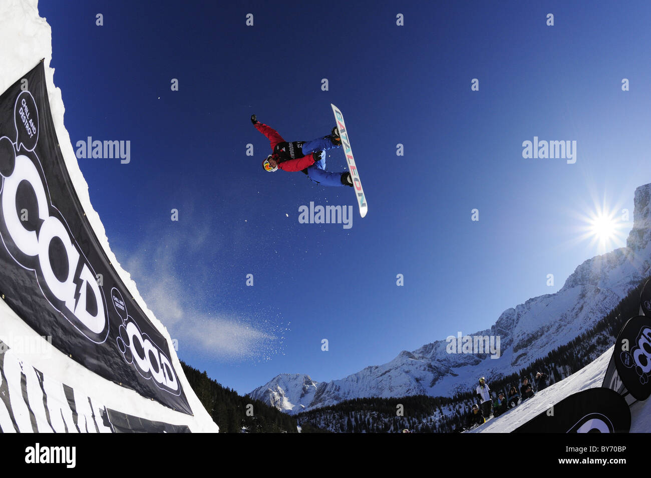 Snowboarder jumping from a kicker, performing a back-flip, funpark ...