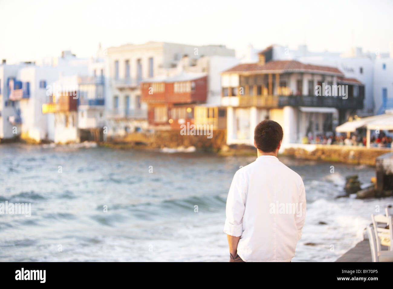 Young man looking at sunset on Mykonos Island, Greece Stock Photo - Alamy