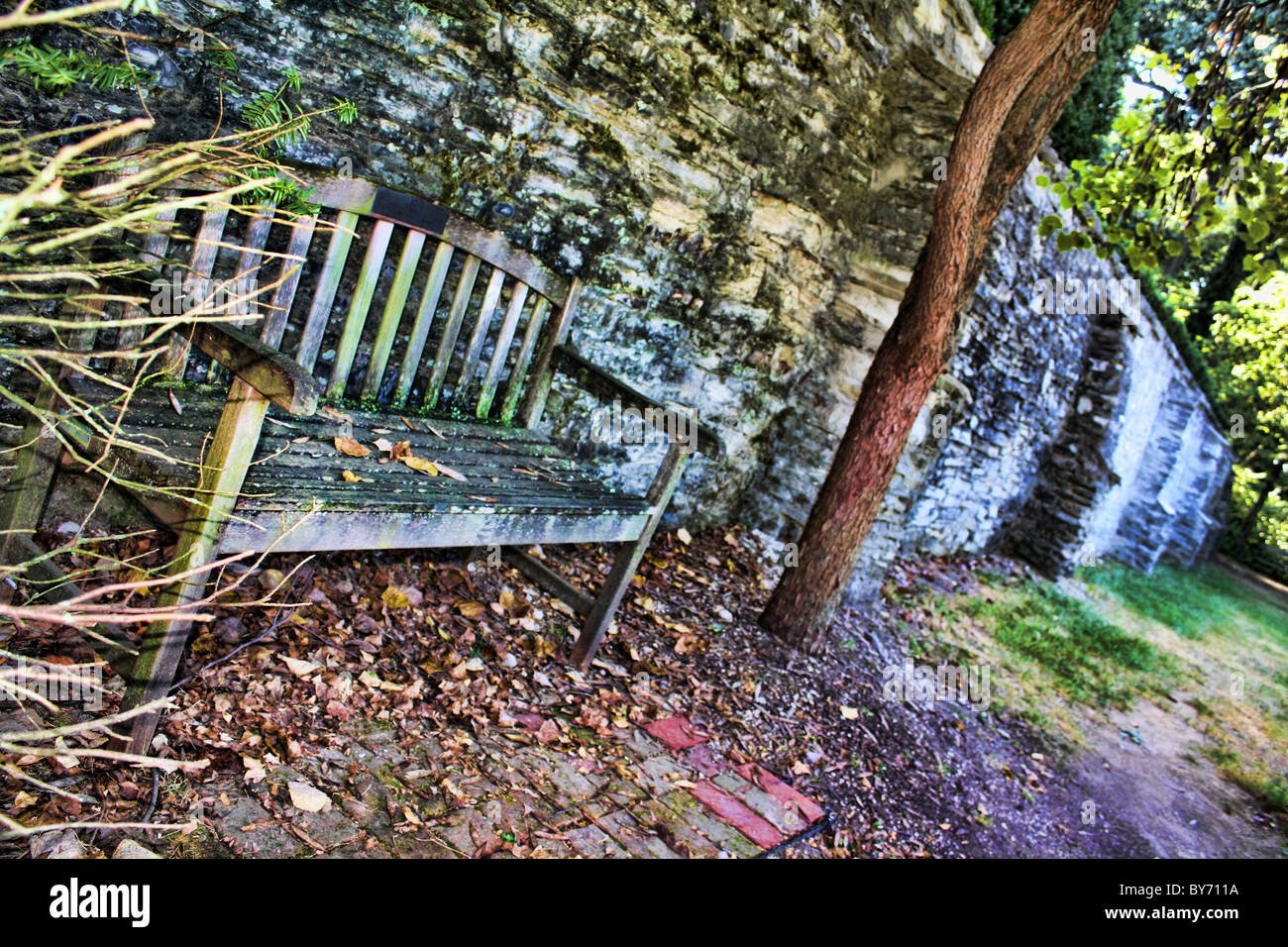 Wooden bench with stone wall Stock Photo - Alamy