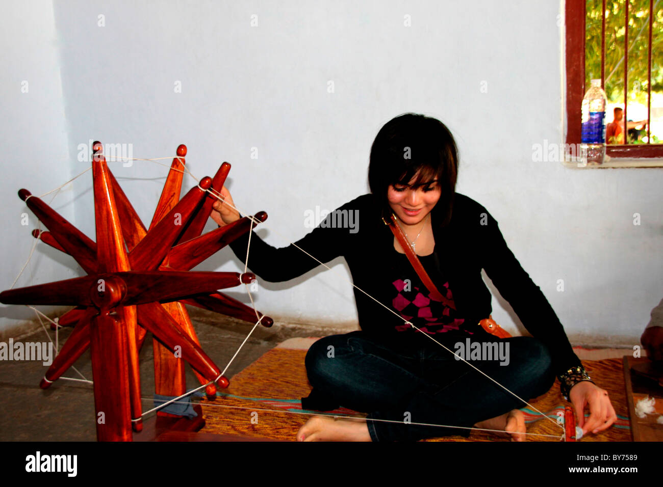 A girl using spinning wheel Stock Photo - Alamy