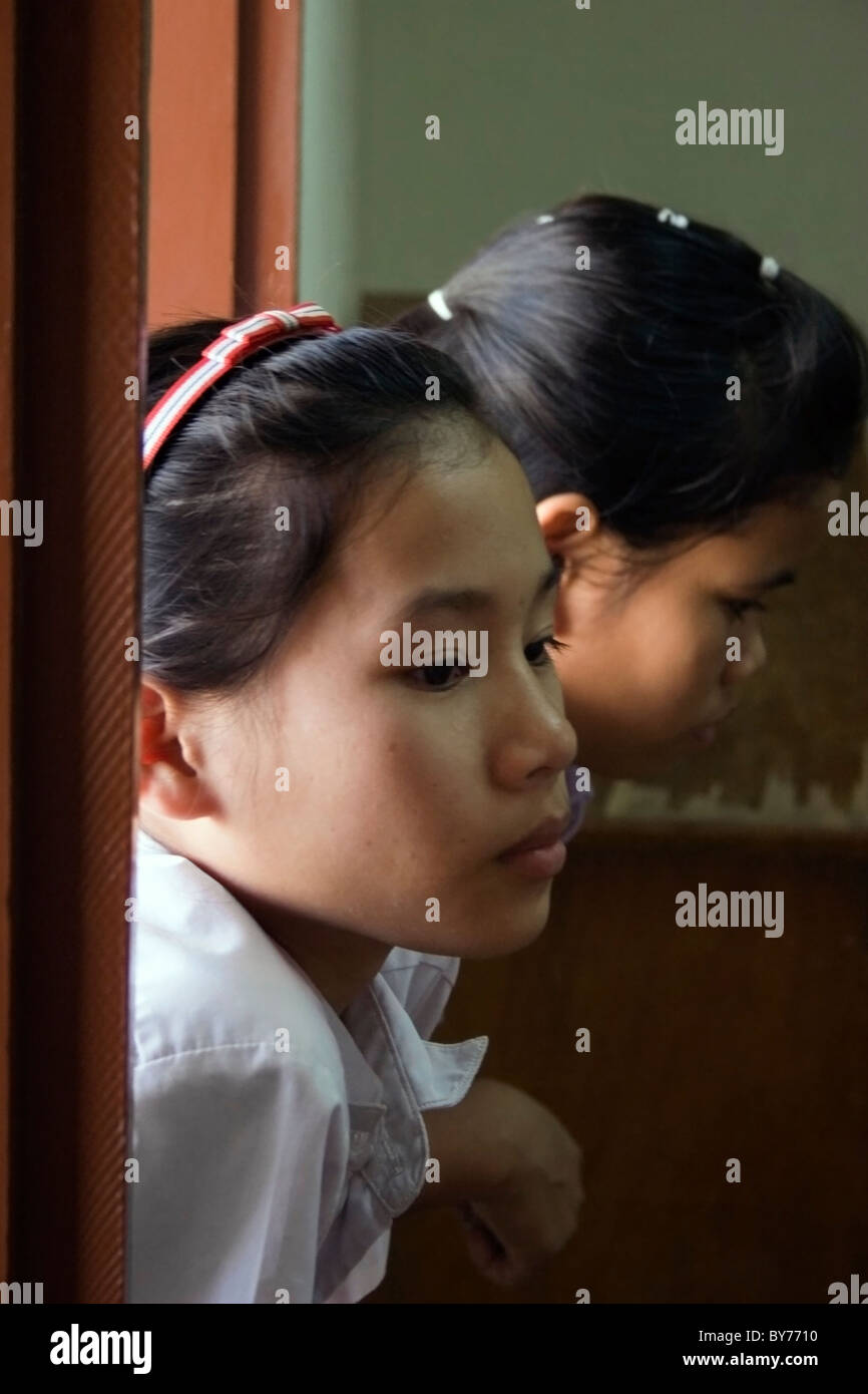 Two young deaf girl students are leaning on a window sill of their ...
