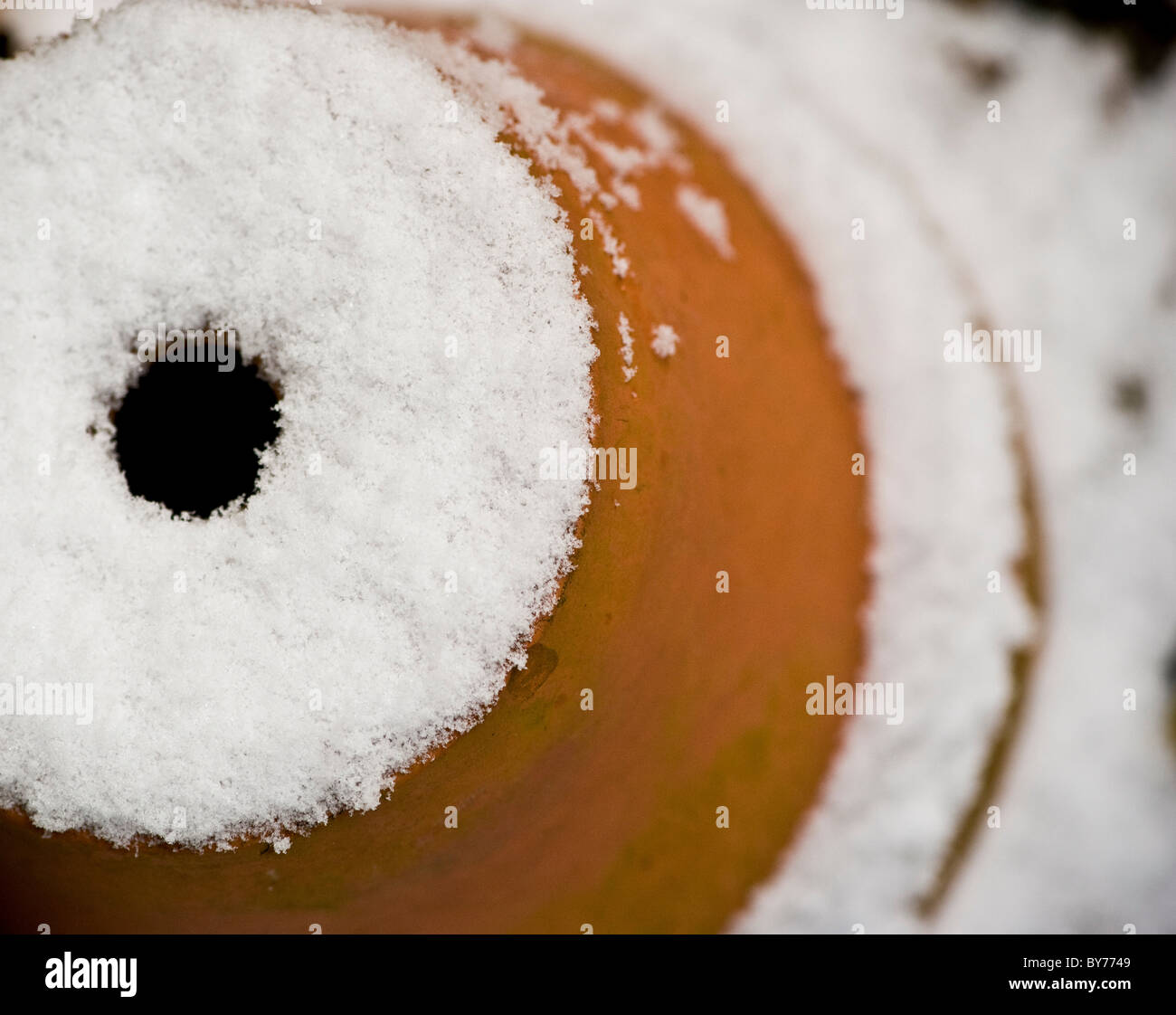 Snow on the base of an upturn terracotta plant pot UK garden Stock ...