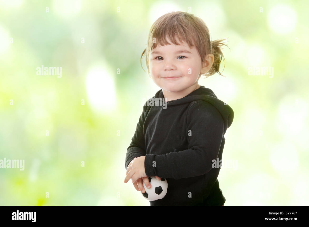 Portrait of a 2 year old girl against abstract green background Stock ...