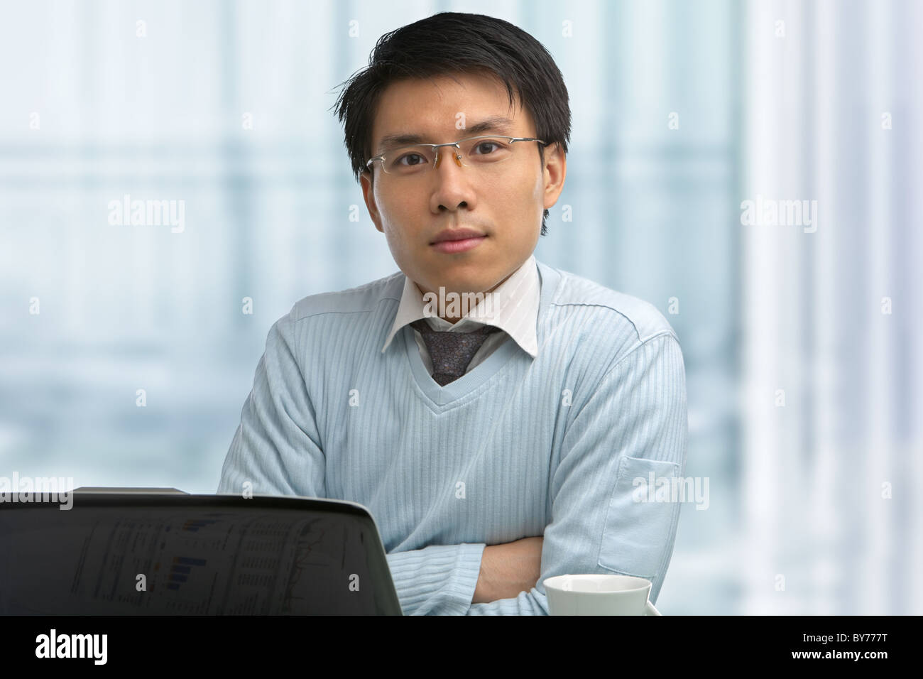 Young Chinese male working in office with laptop Stock Photo - Alamy