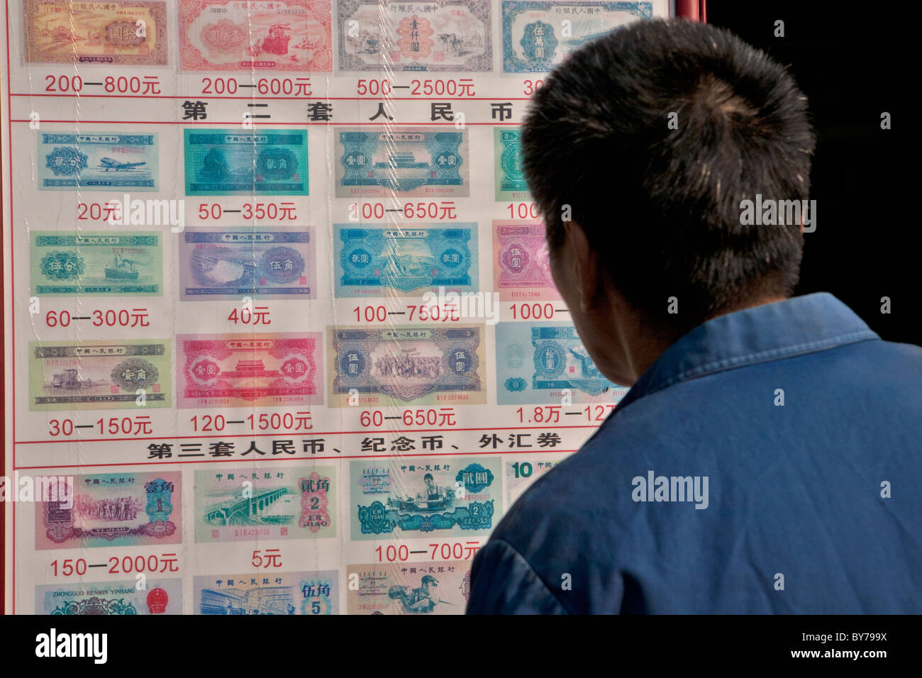 Man looking at chart of currency notes, Duolan Road, Shanghai, China ...