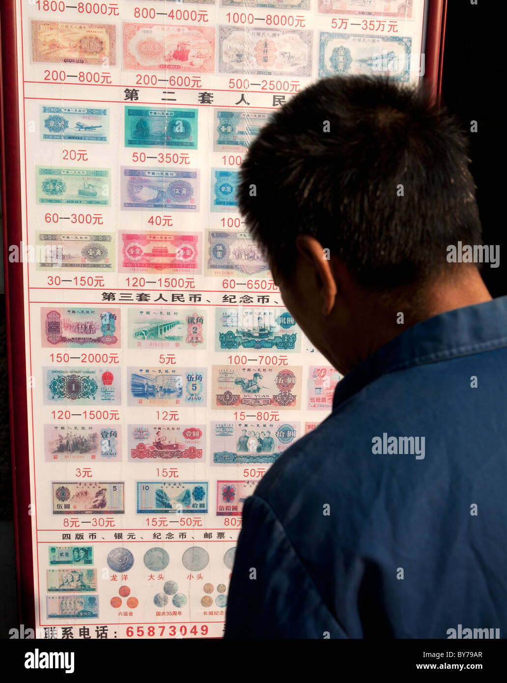 Man looking at chart of currency notes, Duolan Road, Shanghai, China ...