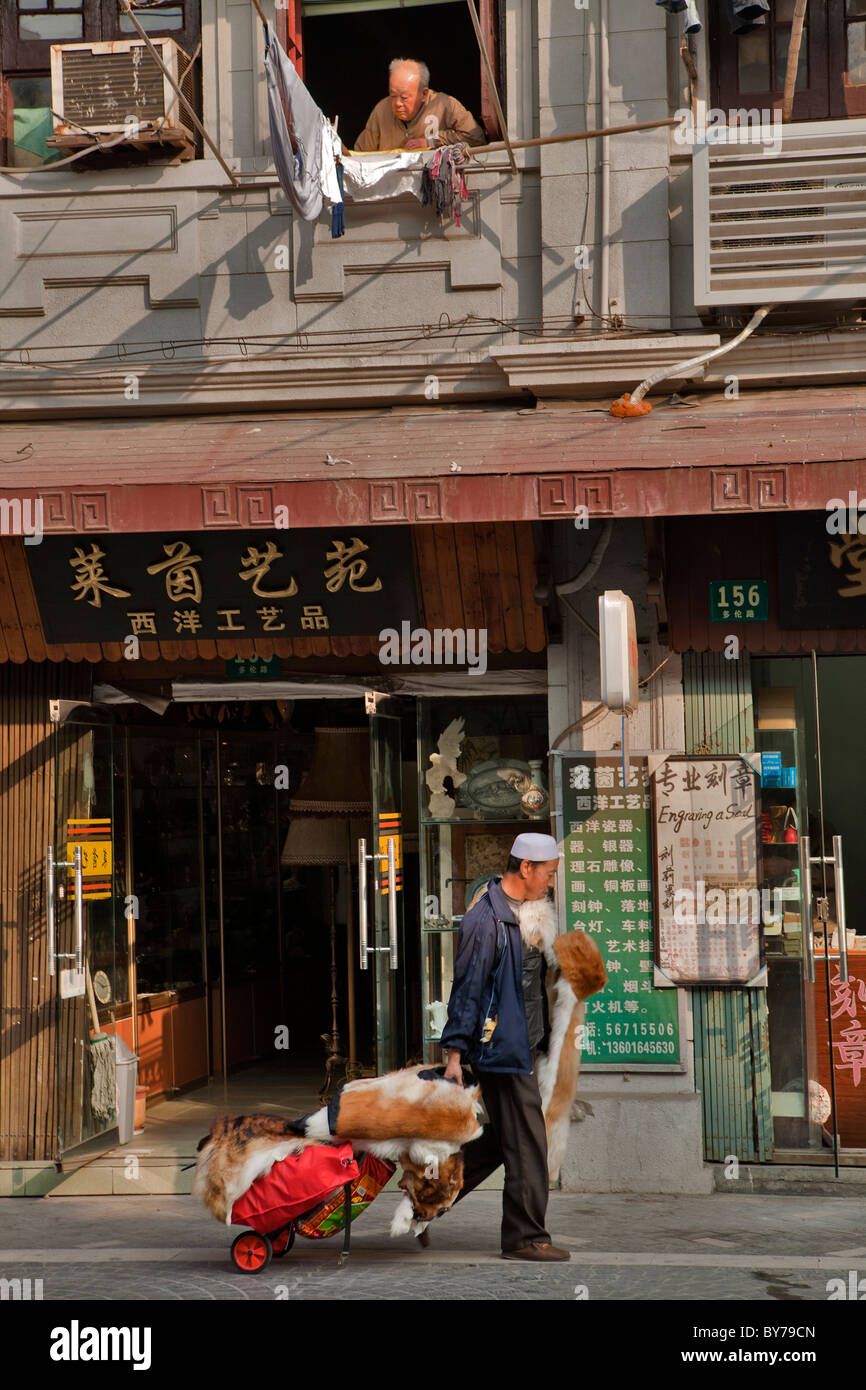 Man pulling trolley in front of building, Duolan Road, Shanghai, China ...