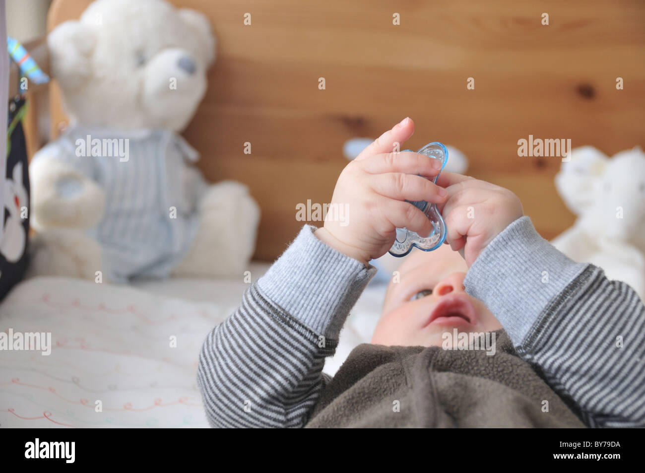 Baby playing with his dummy Stock Photo - Alamy