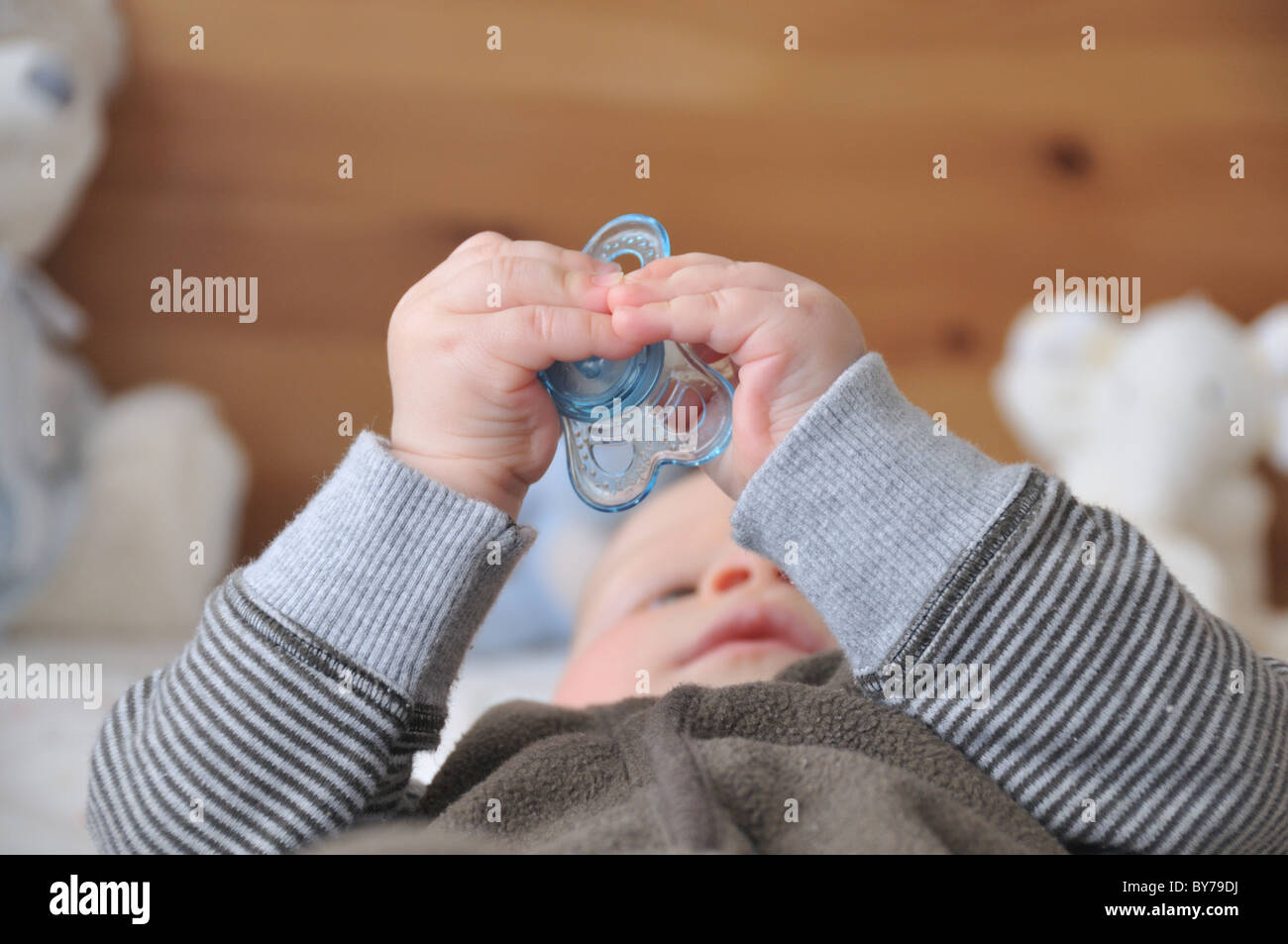 Baby playing with his dummy Stock Photo - Alamy