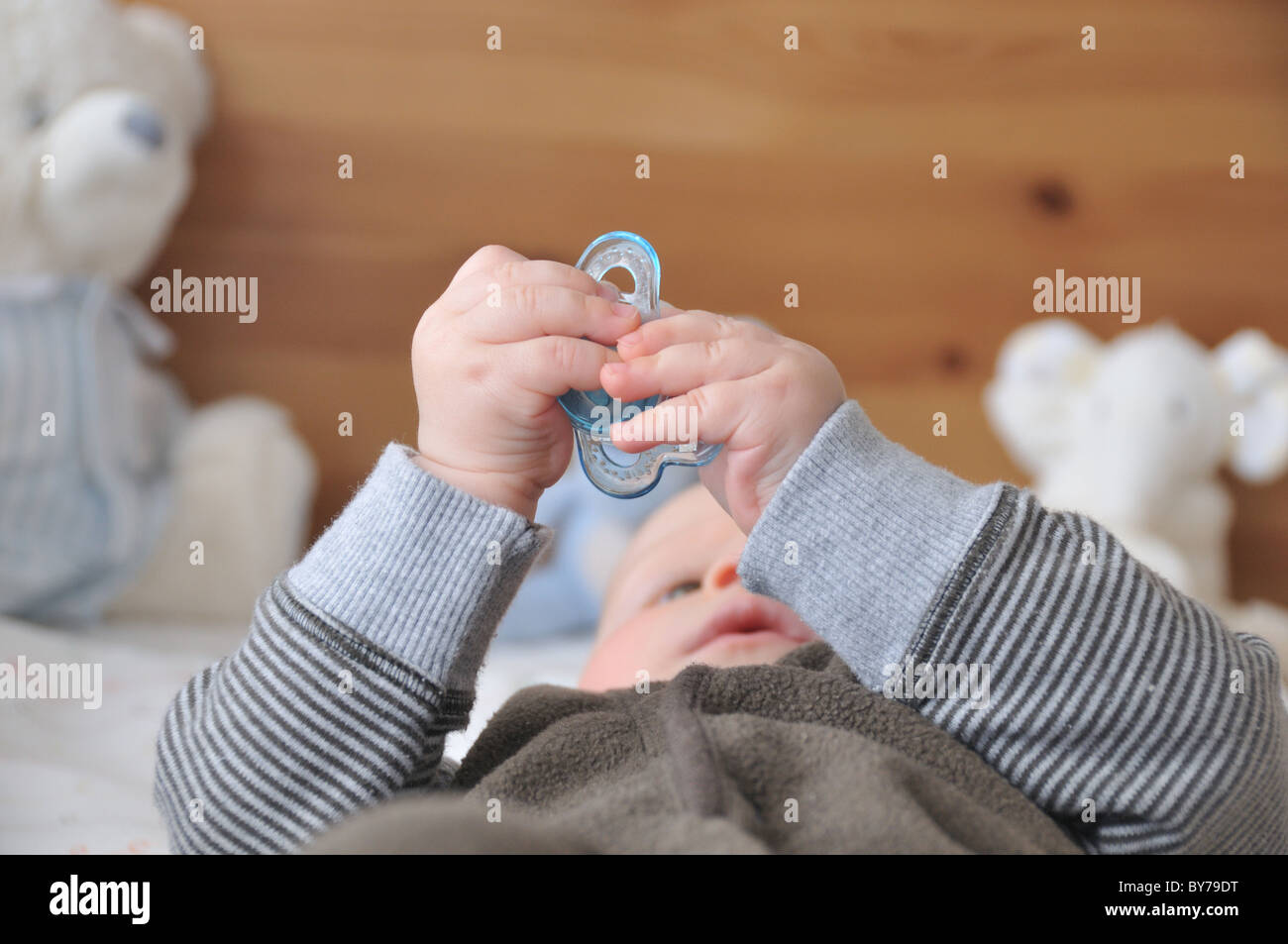 Baby playing with his dummy Stock Photo - Alamy