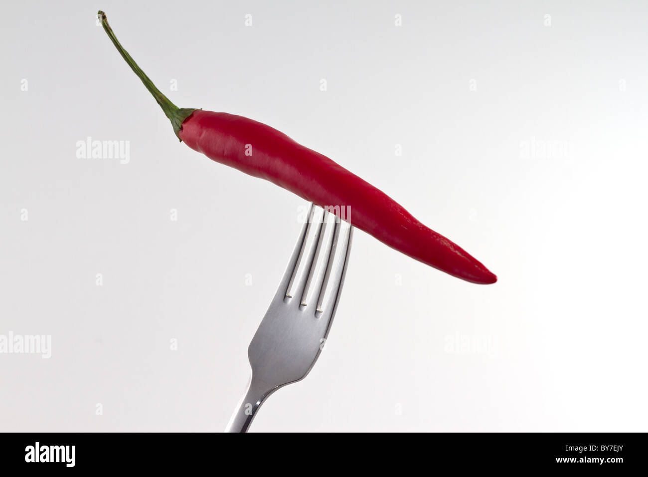 Red hot chili pepper on a fork isolated on white background Stock Photo ...