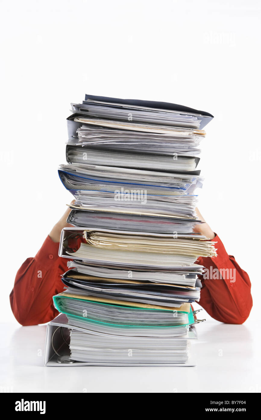 Pile of paperworks with stress businessman on back, over white ...