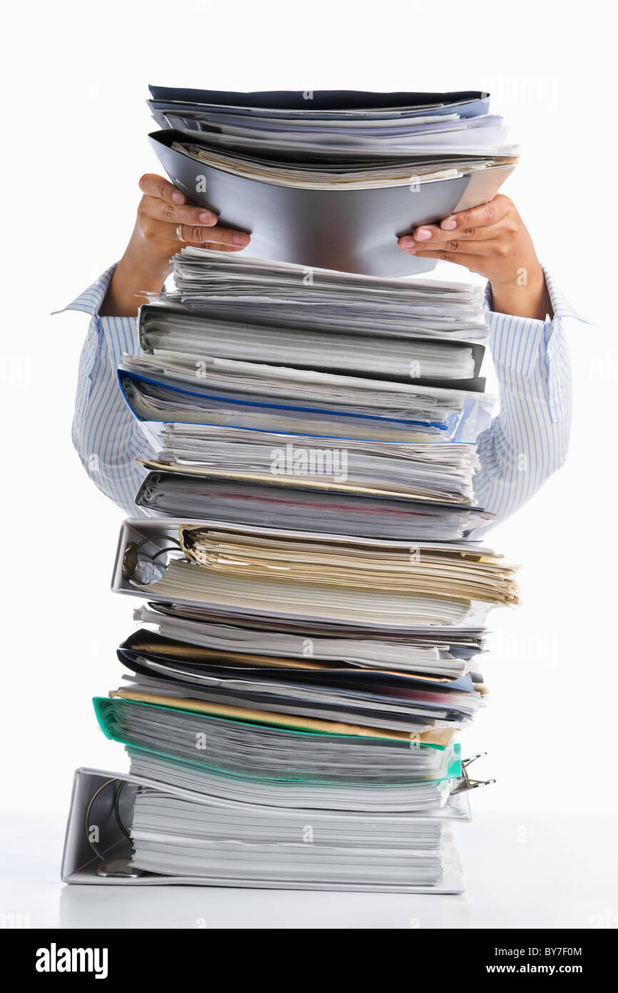 Female hand put paper into high pile paperwork Stock Photo - Alamy