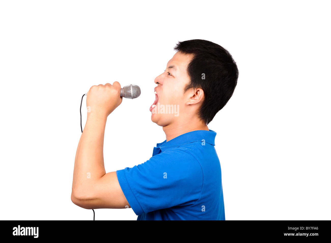 Young man with a microphone singing Stock Photo - Alamy