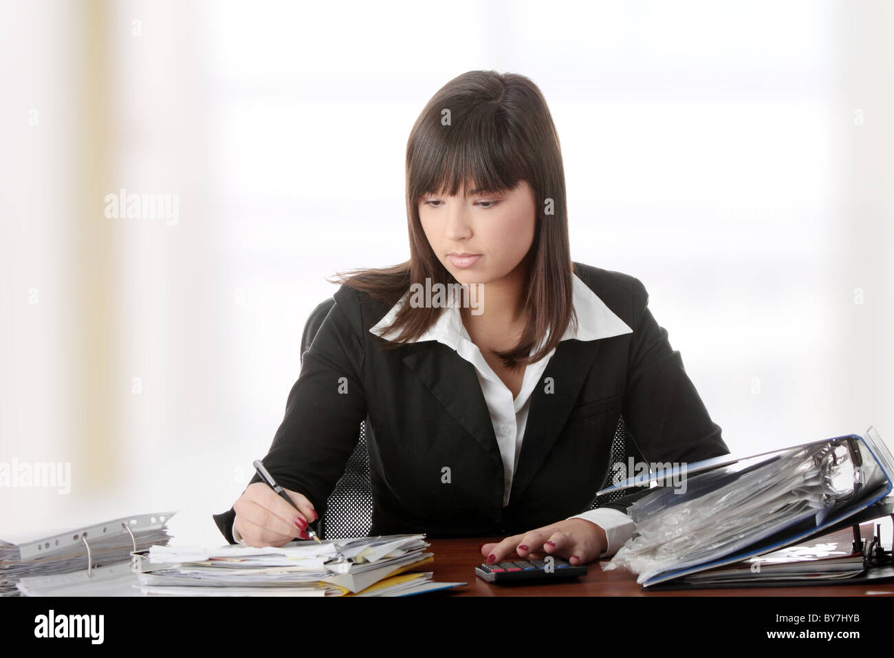 Female executive filling out tax forms while sitting at her desk Stock ...