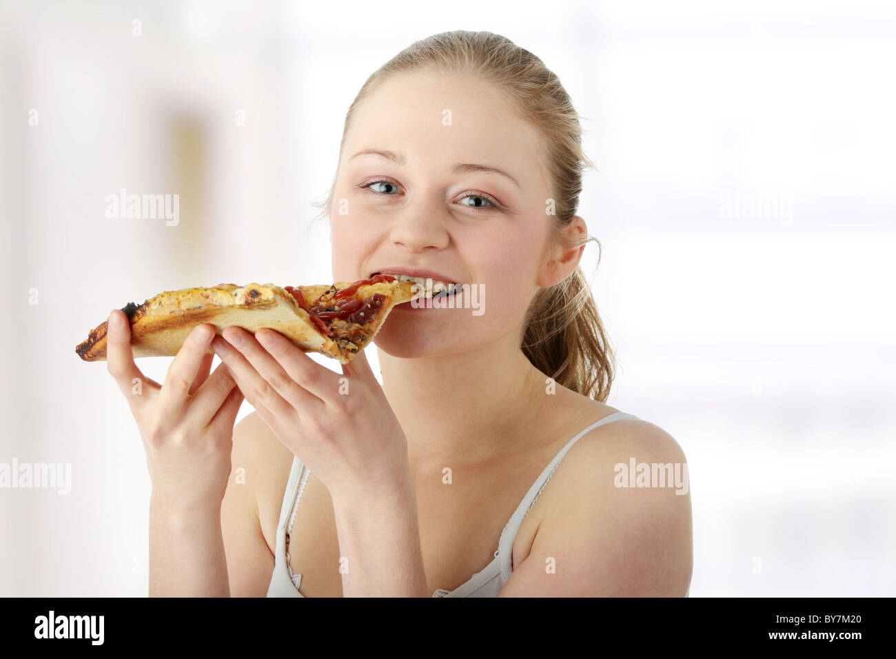Young happy woman eating pizza Stock Photo - Alamy