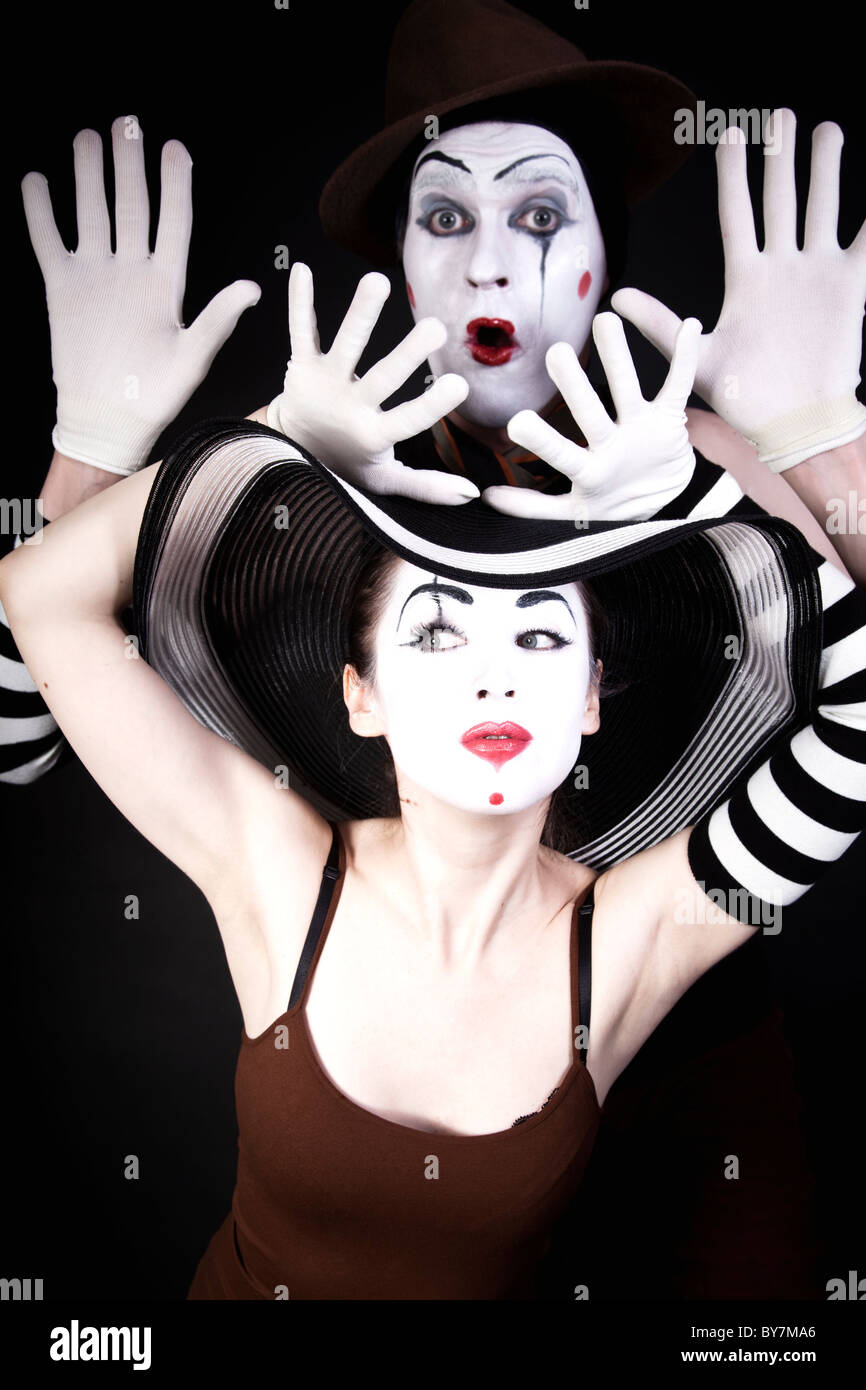 Portrait of two mimes in hats on black background Stock Photo - Alamy