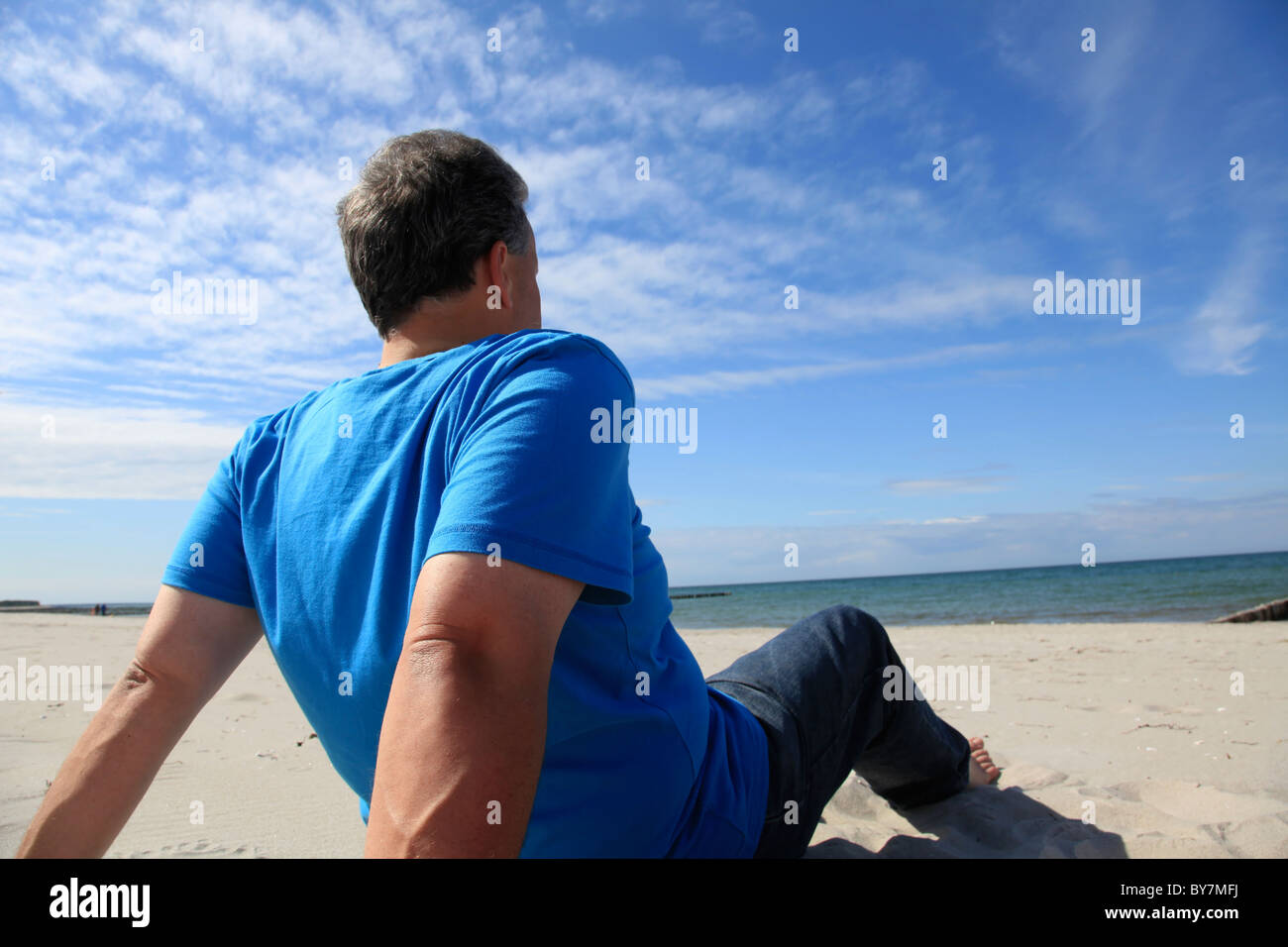 Man sitting on the beach Stock Photo - Alamy