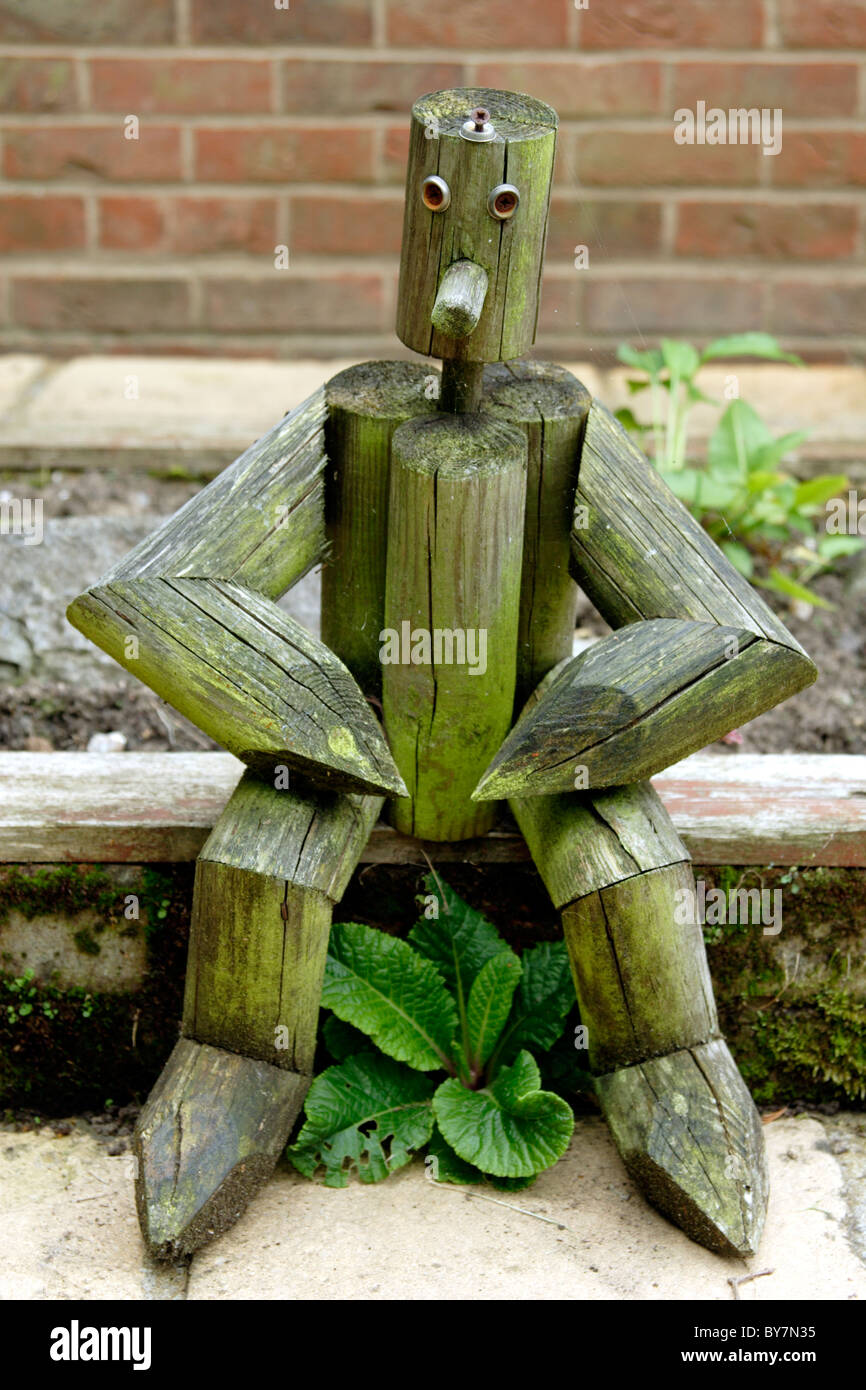 Wooden figure sitting in garden Stock Photo - Alamy