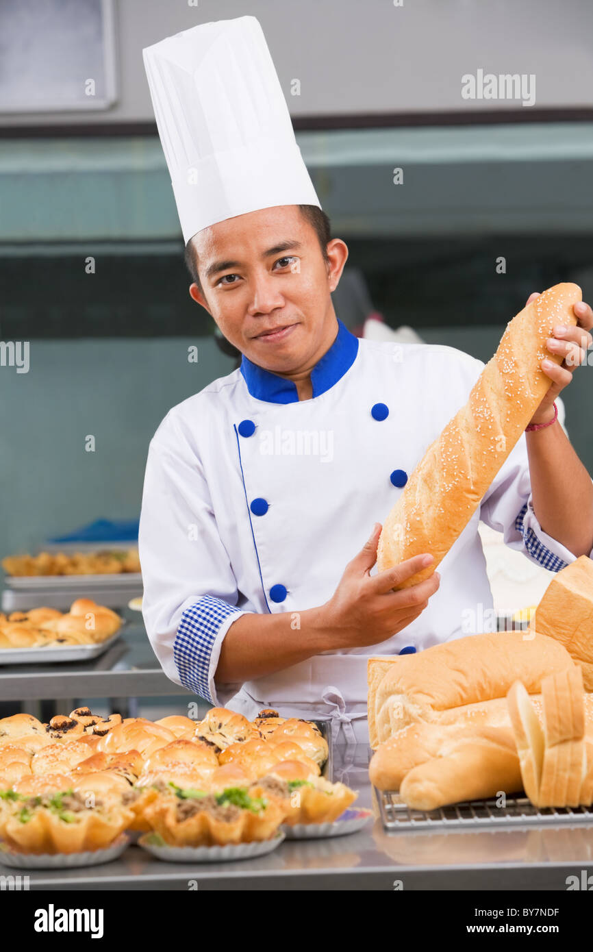 Baker holding the bread in commercial kitchen Stock Photo - Alamy