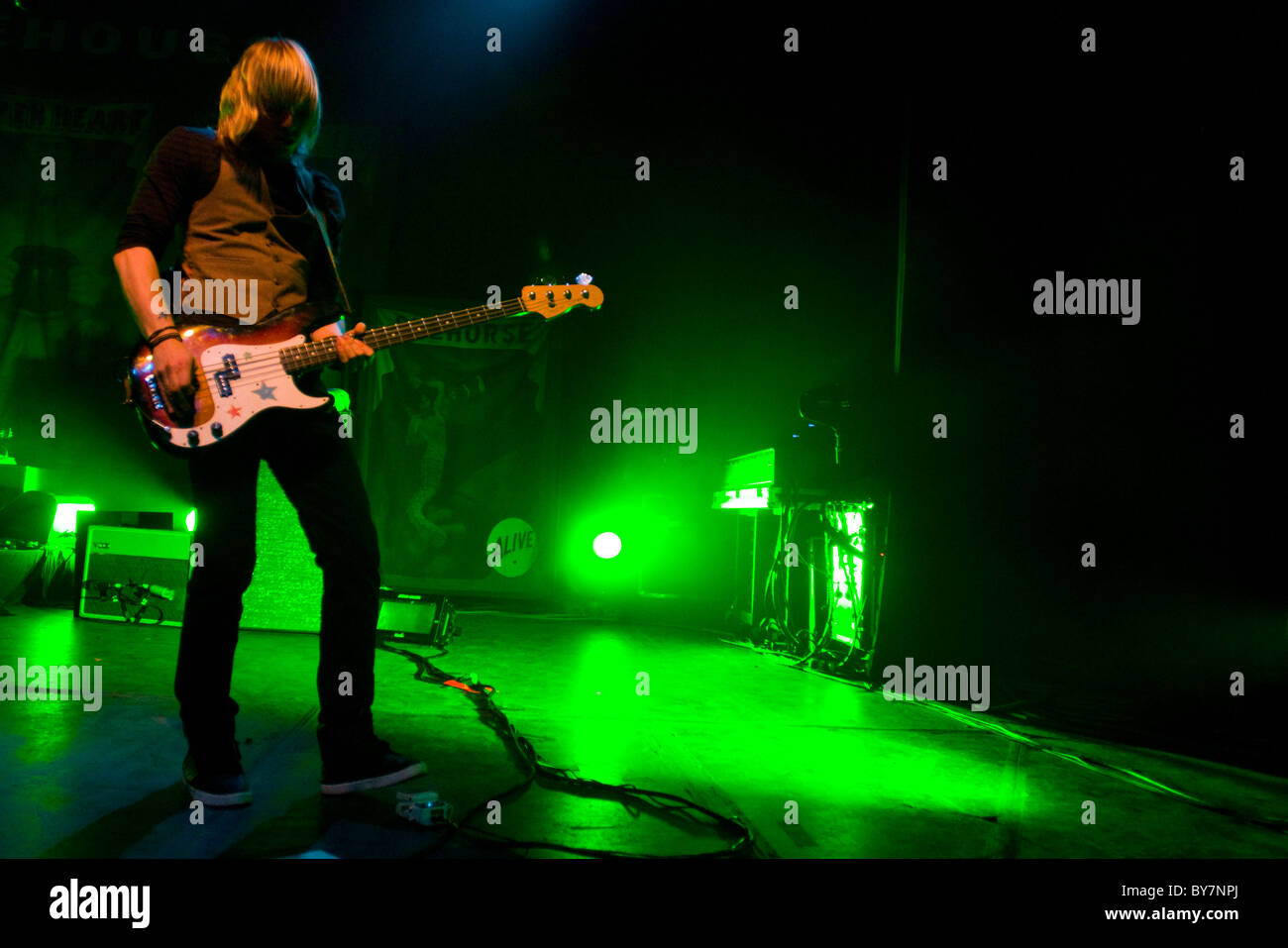Bryce Soderberg, bass player for Lifehouse plays in front of the green ...