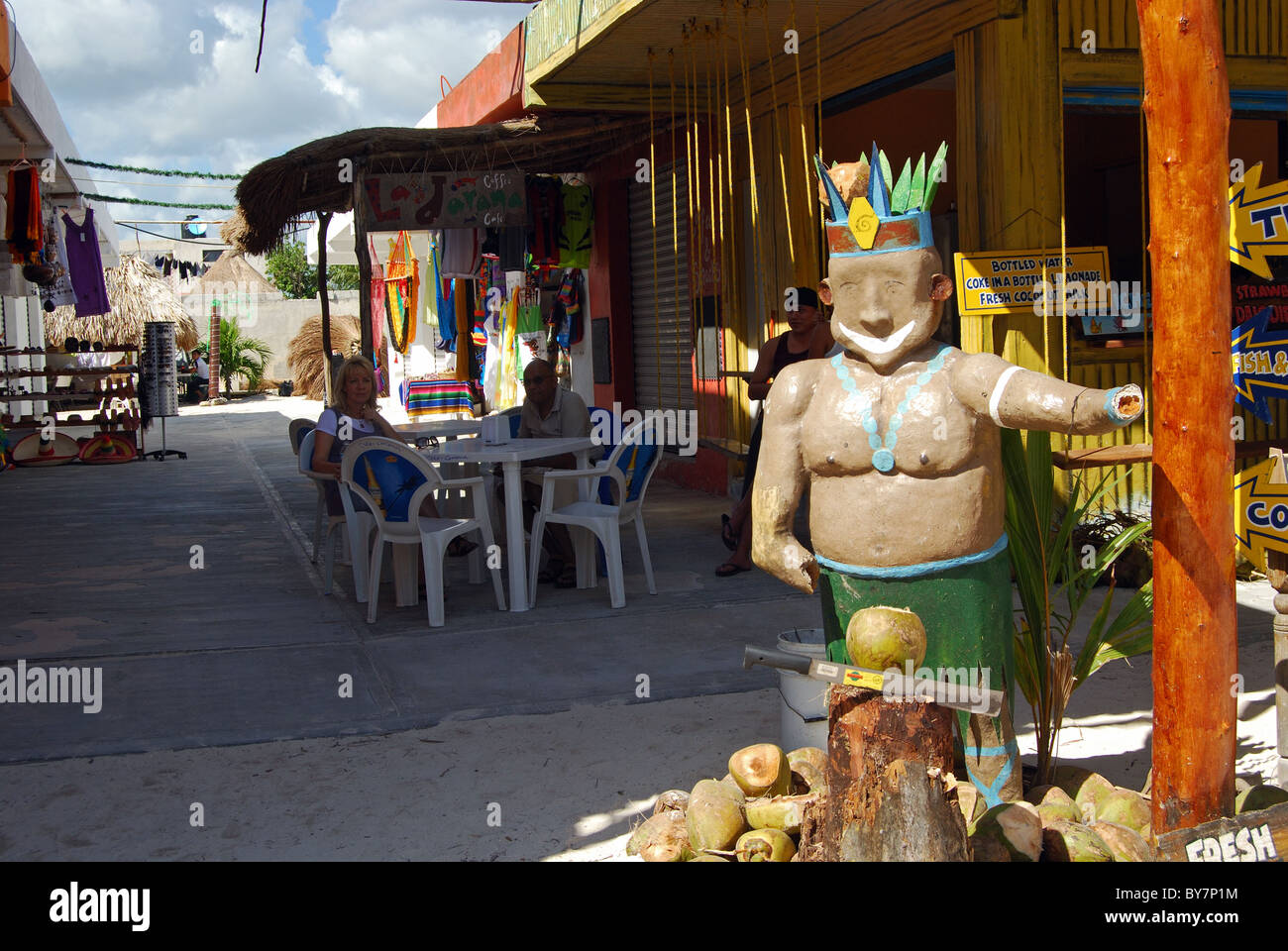 Wooden Mayan man chopping coconuts outside bar, Costa Maya, South ...