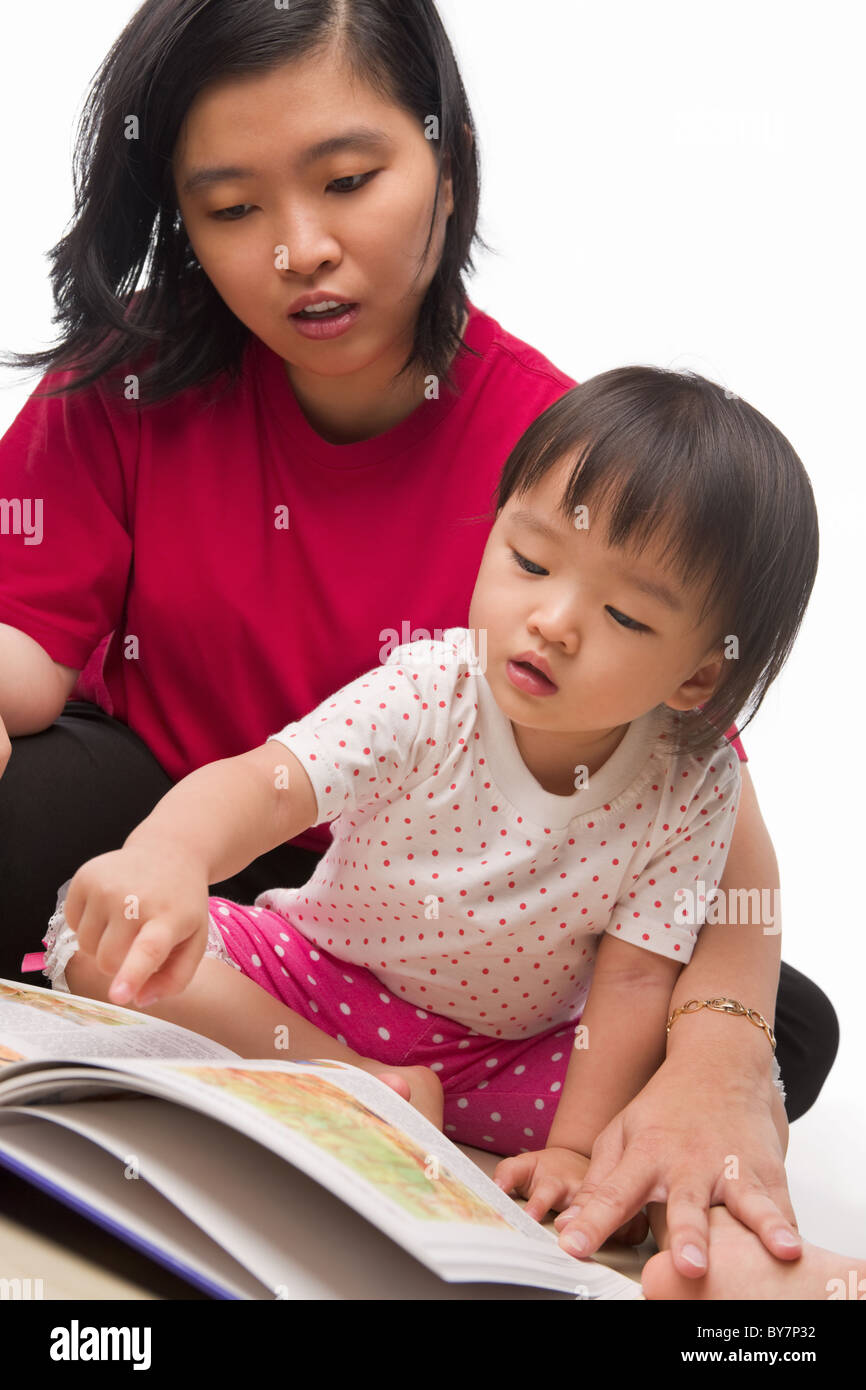 Chinese mother teaching her little girl with book Stock Photo - Alamy
