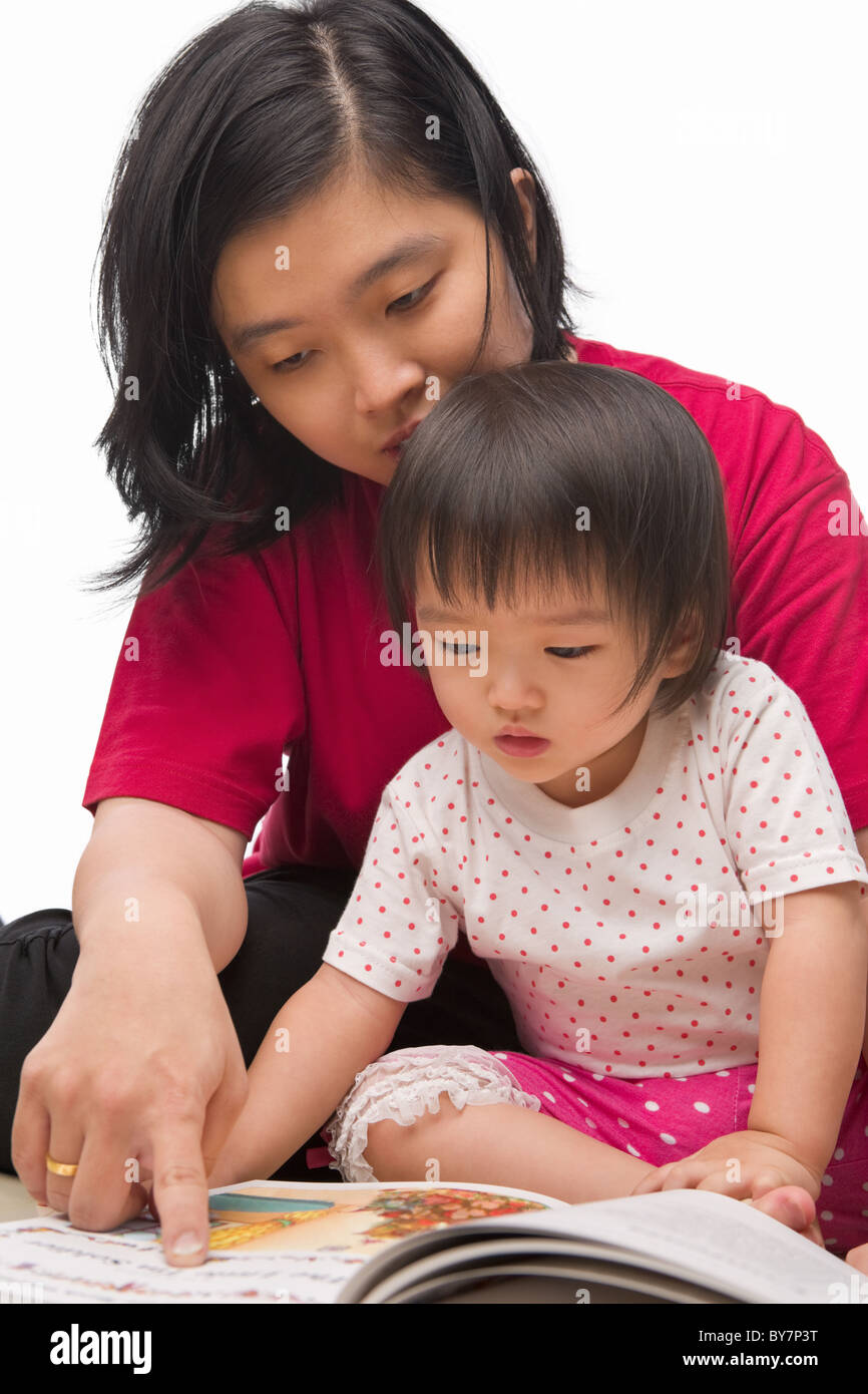 Chinese mother teaching her little girl with book Stock Photo - Alamy