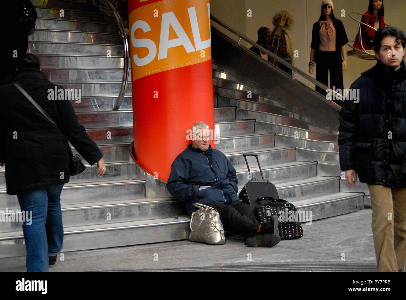 Man tired of shopping in London sitting down exhausted Stock Photo - Alamy