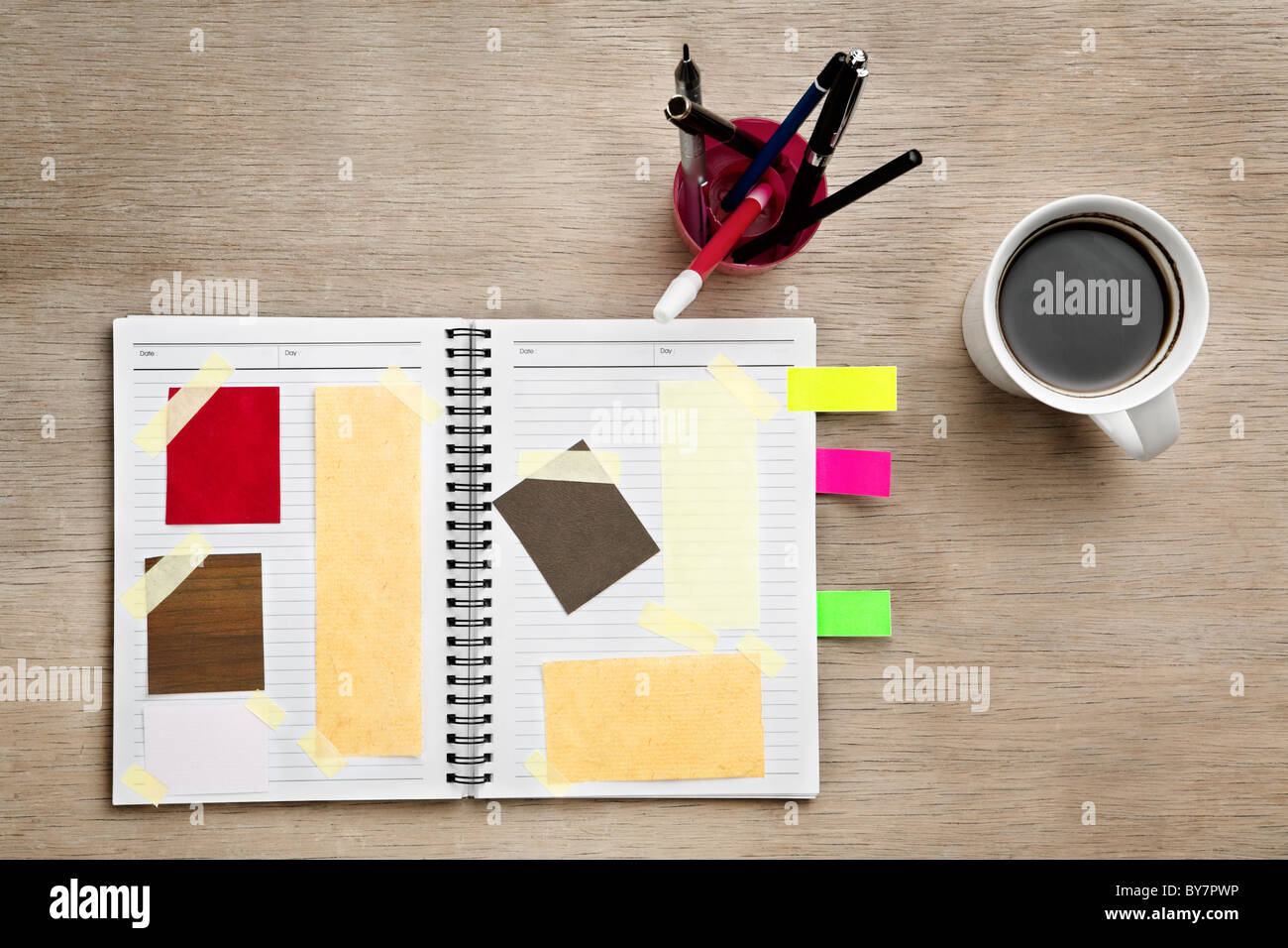 Designer scrap book, filled with various paper and material on wooden ...