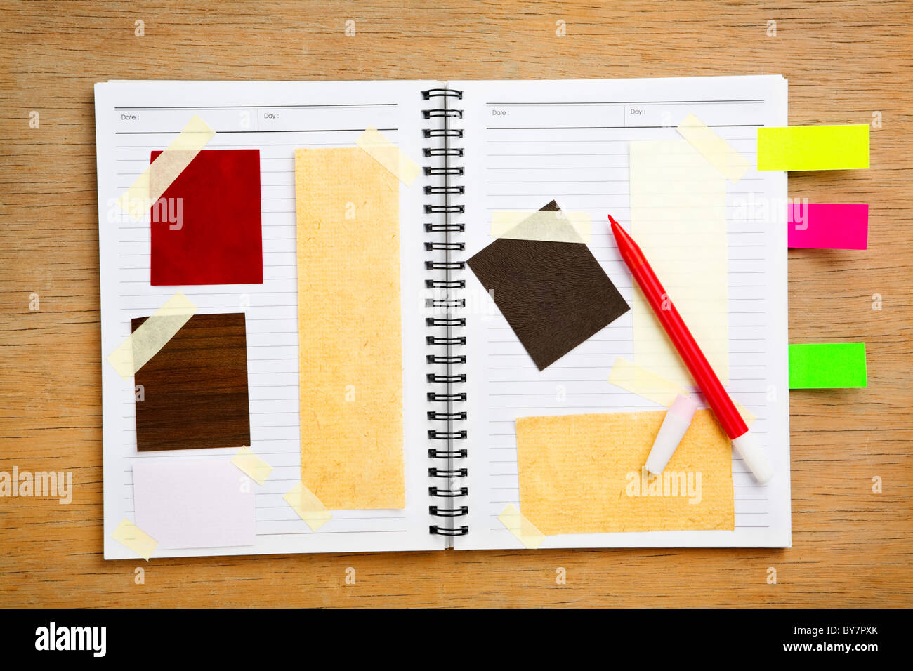 Designer scrap book, filled with various paper and material on wooden ...