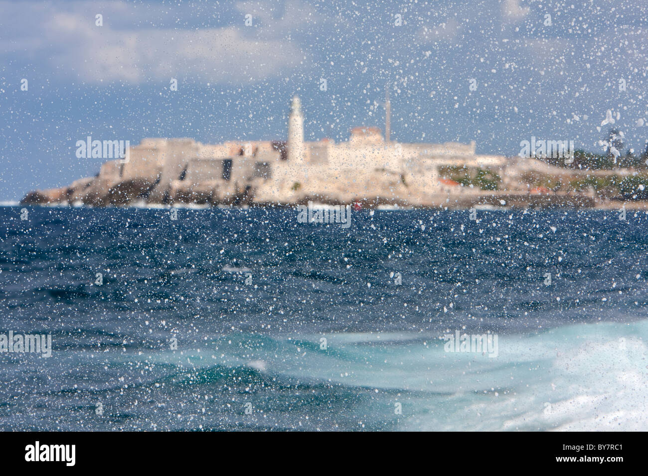 Cuba, Havana. Waves splash on the Malecon sea wall. In the background ...