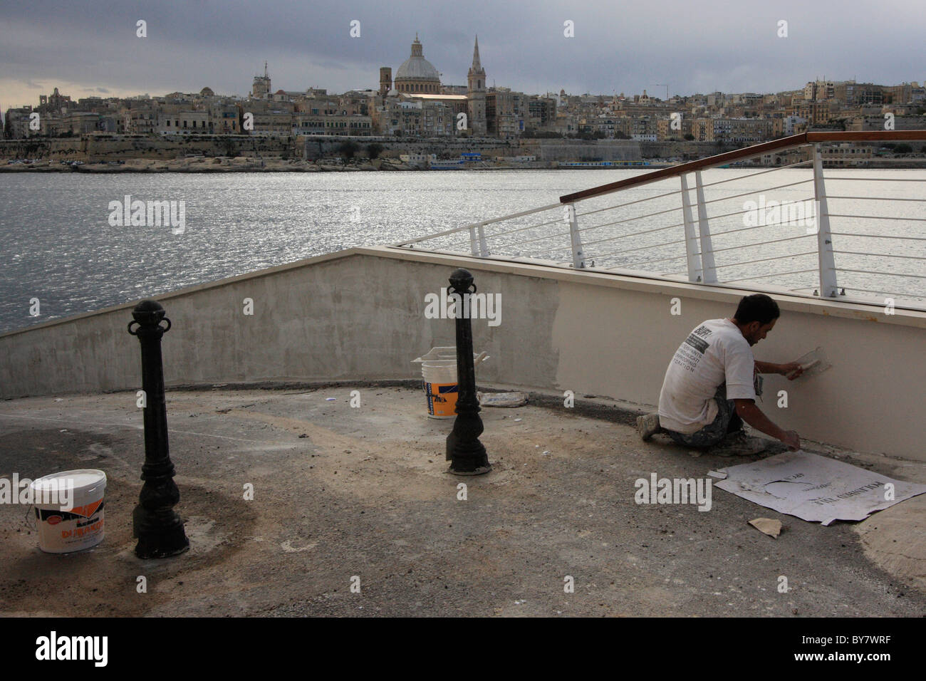 painter painting a wall,churches and old buildings on the harbour of ...