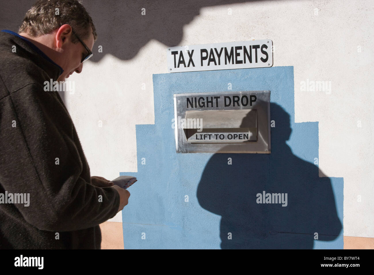 A middle aged man getting ready to mail his tax payment to the IRS, USA ...
