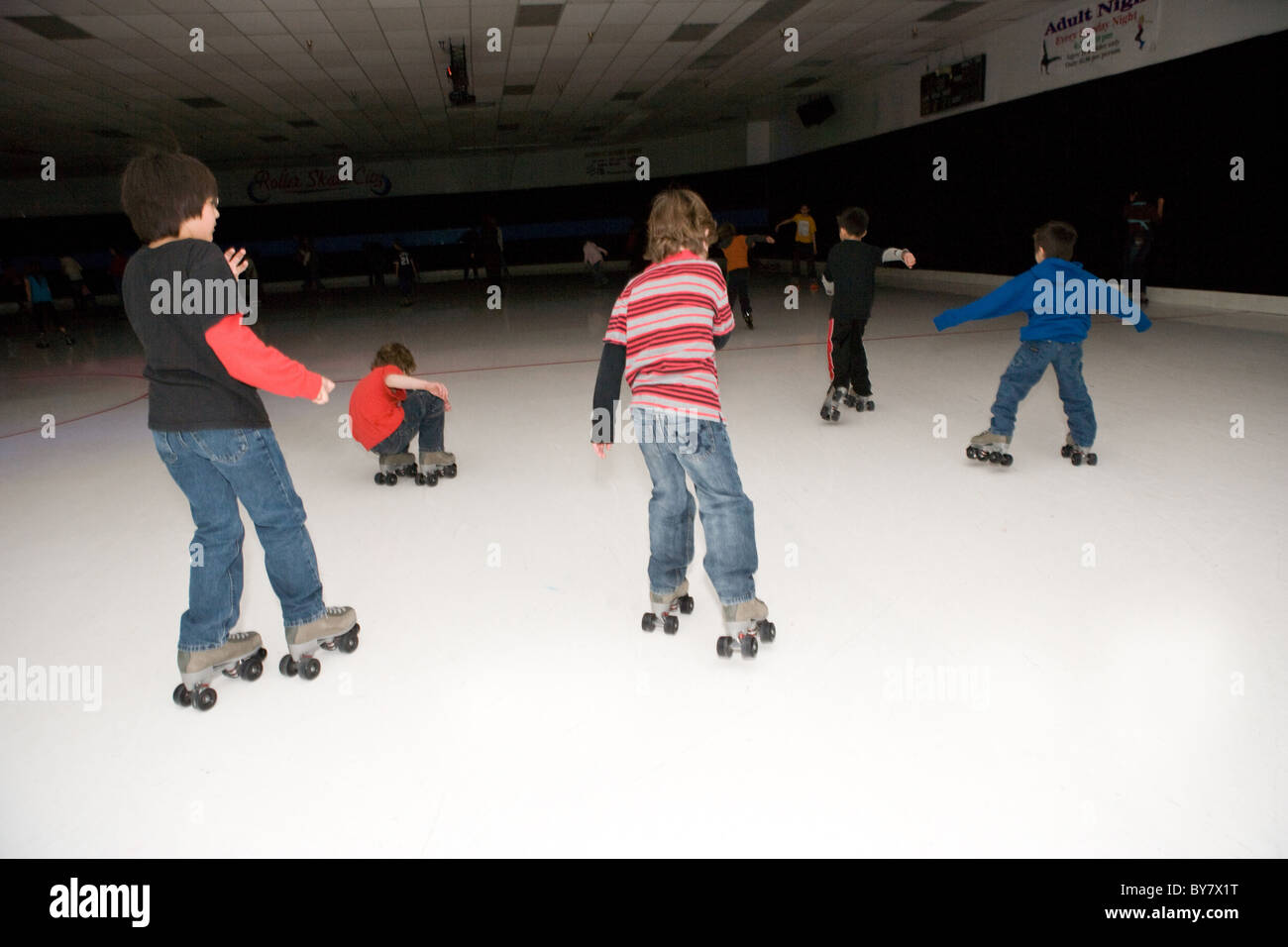 Children rollerskating in a dark skating rink, United States Stock ...