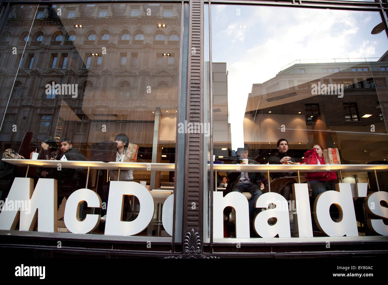 People sit eating in the window of McDonald's at Leicester Square ...