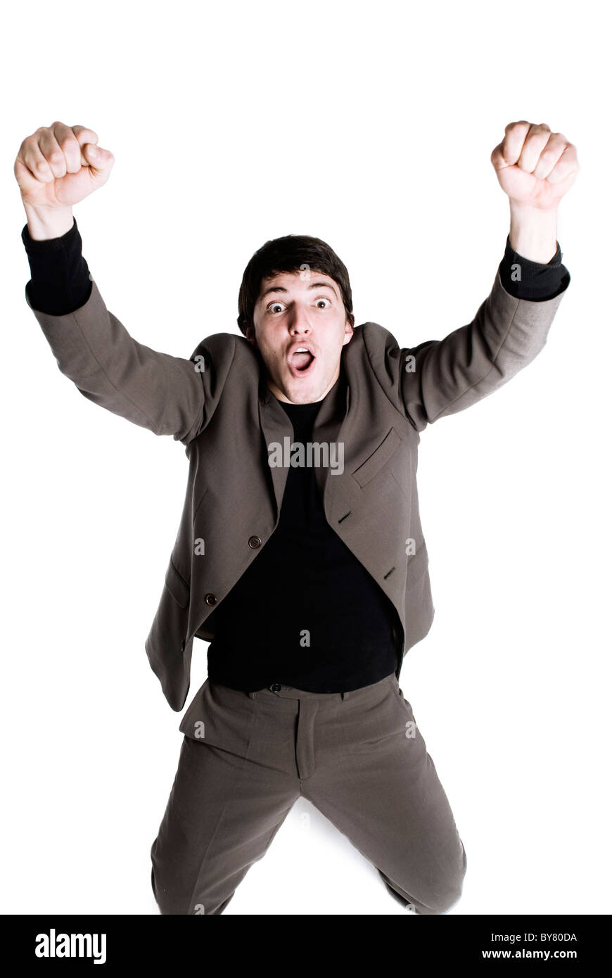 young businessman with hands up and face of victory, happy, elated ...