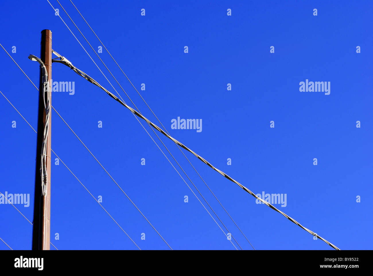 low voltage power line with blue sky background Stock Photo - Alamy
