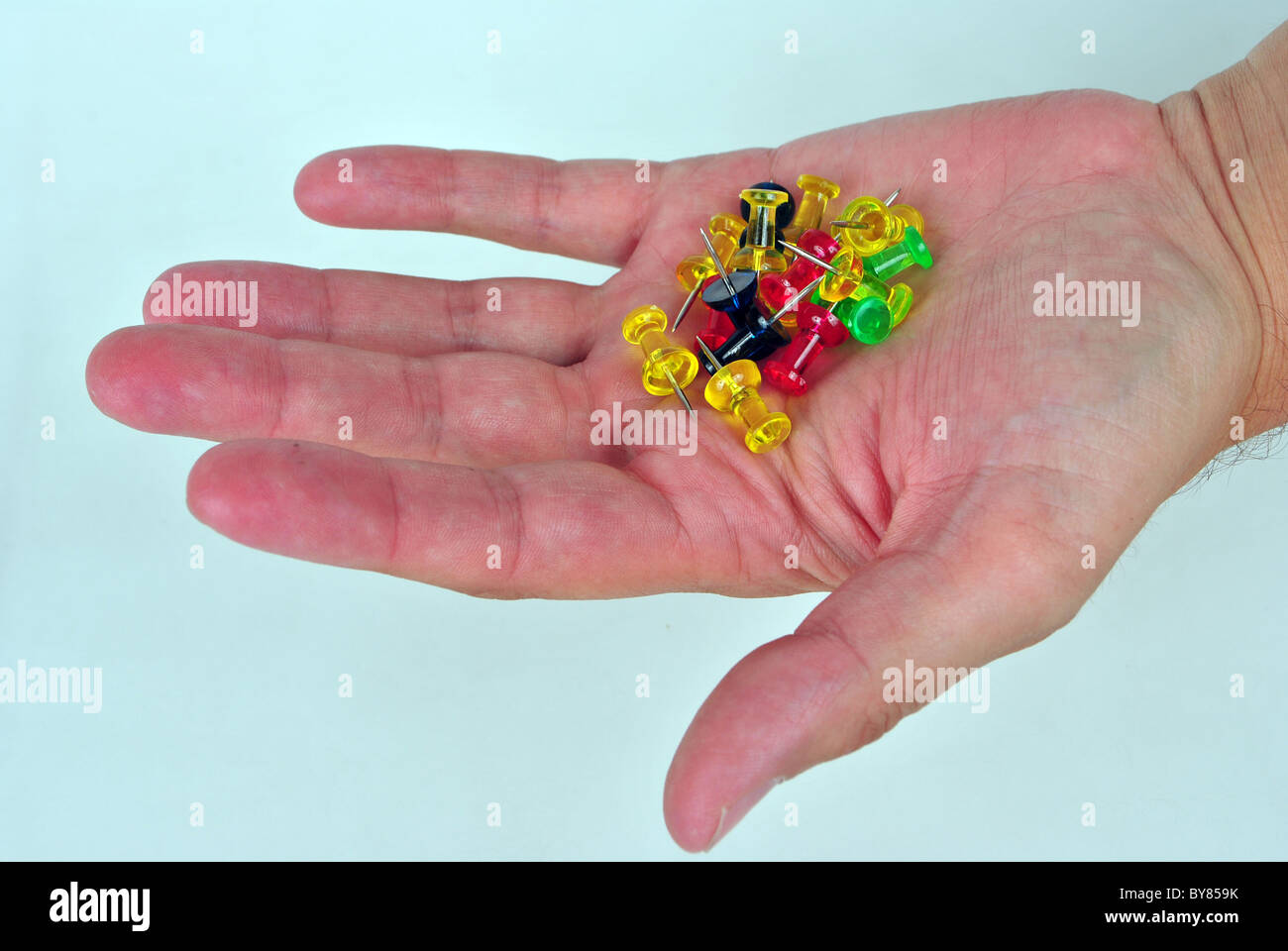 colored pins in his hand Stock Photo - Alamy